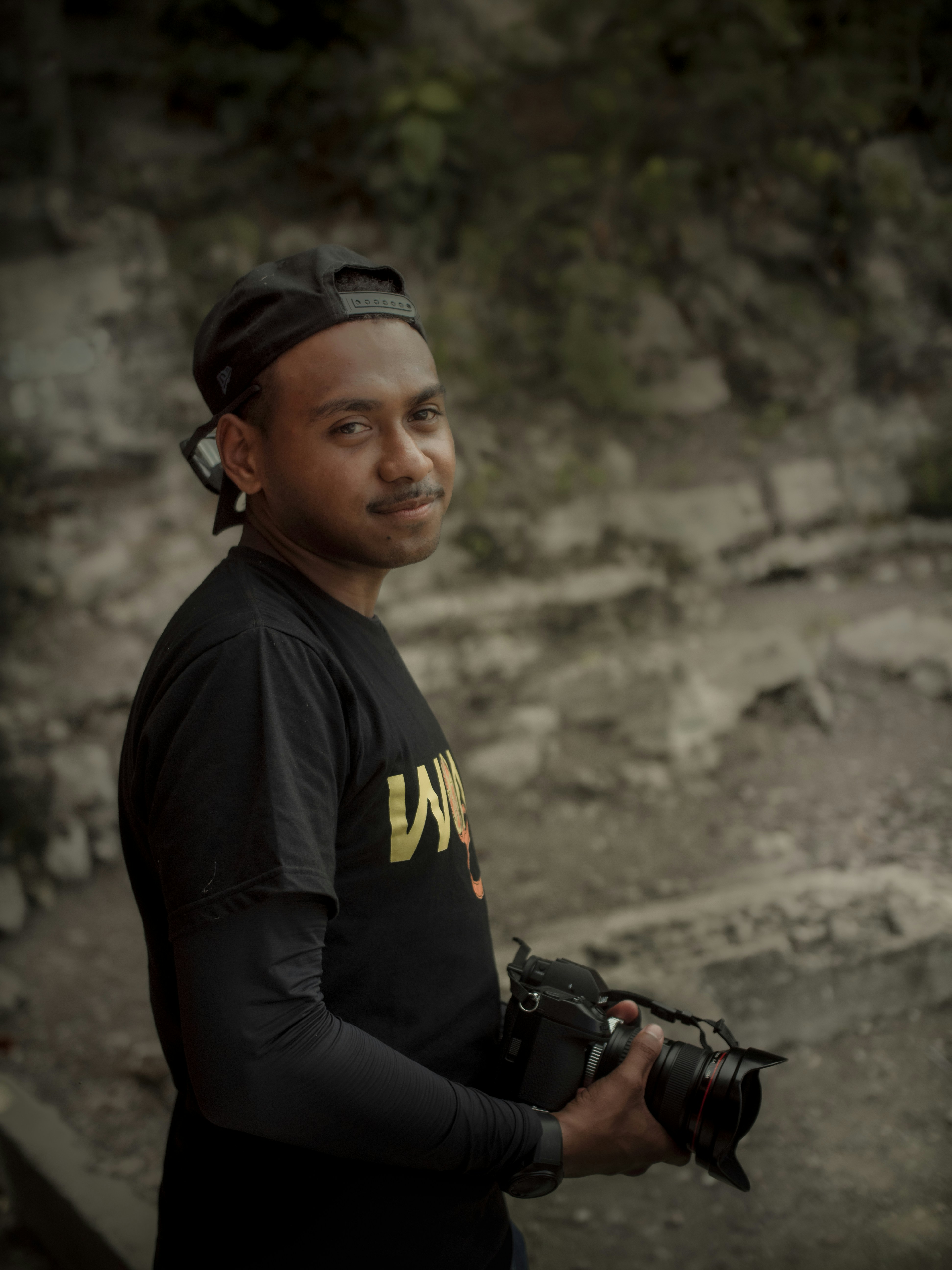 Portrait Among Weathered Granite: A Photographer Pauses with Lens in Hand