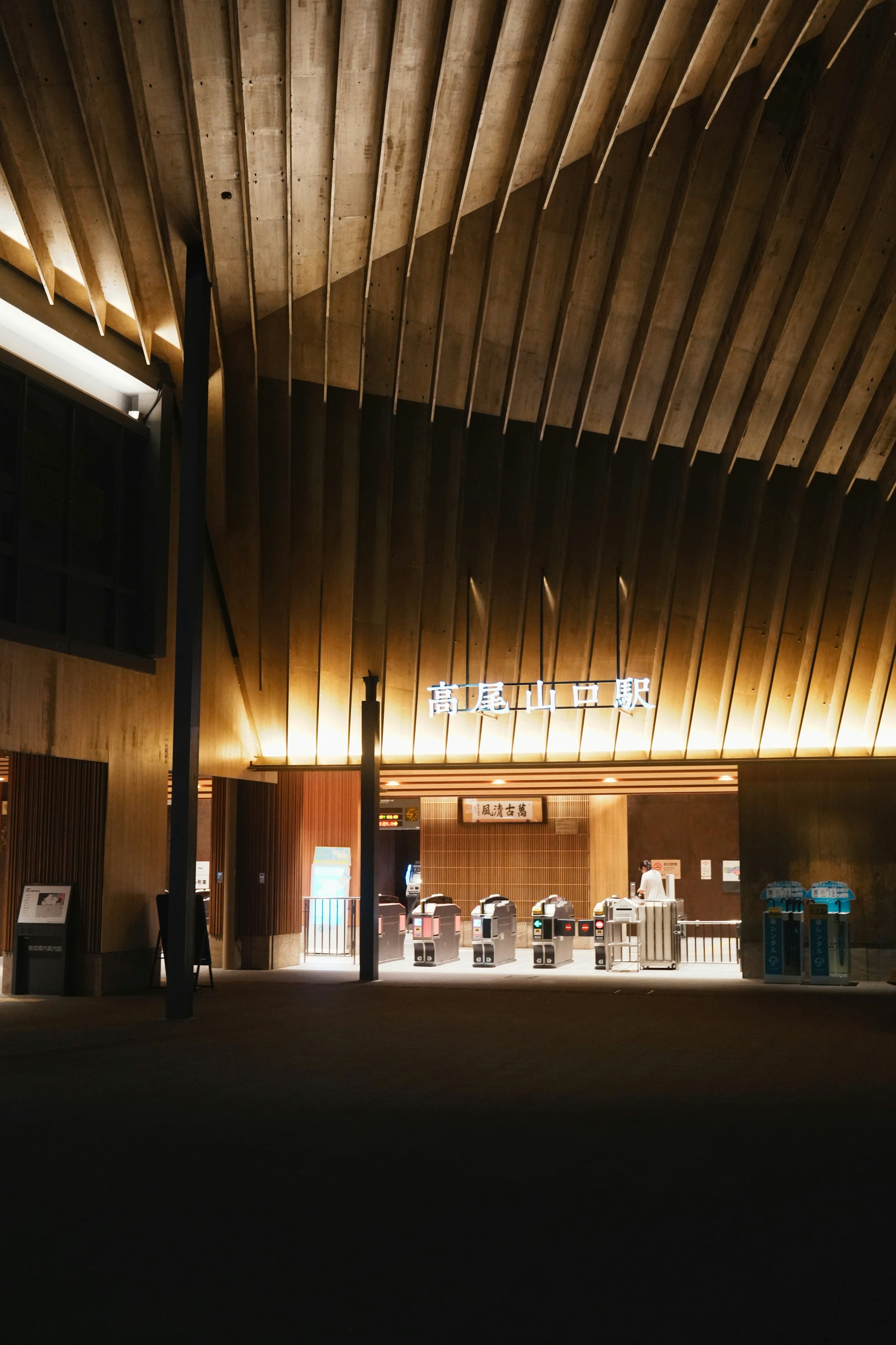 Amber Glow Under a Timber Rib Canopy at Night Station Entrance