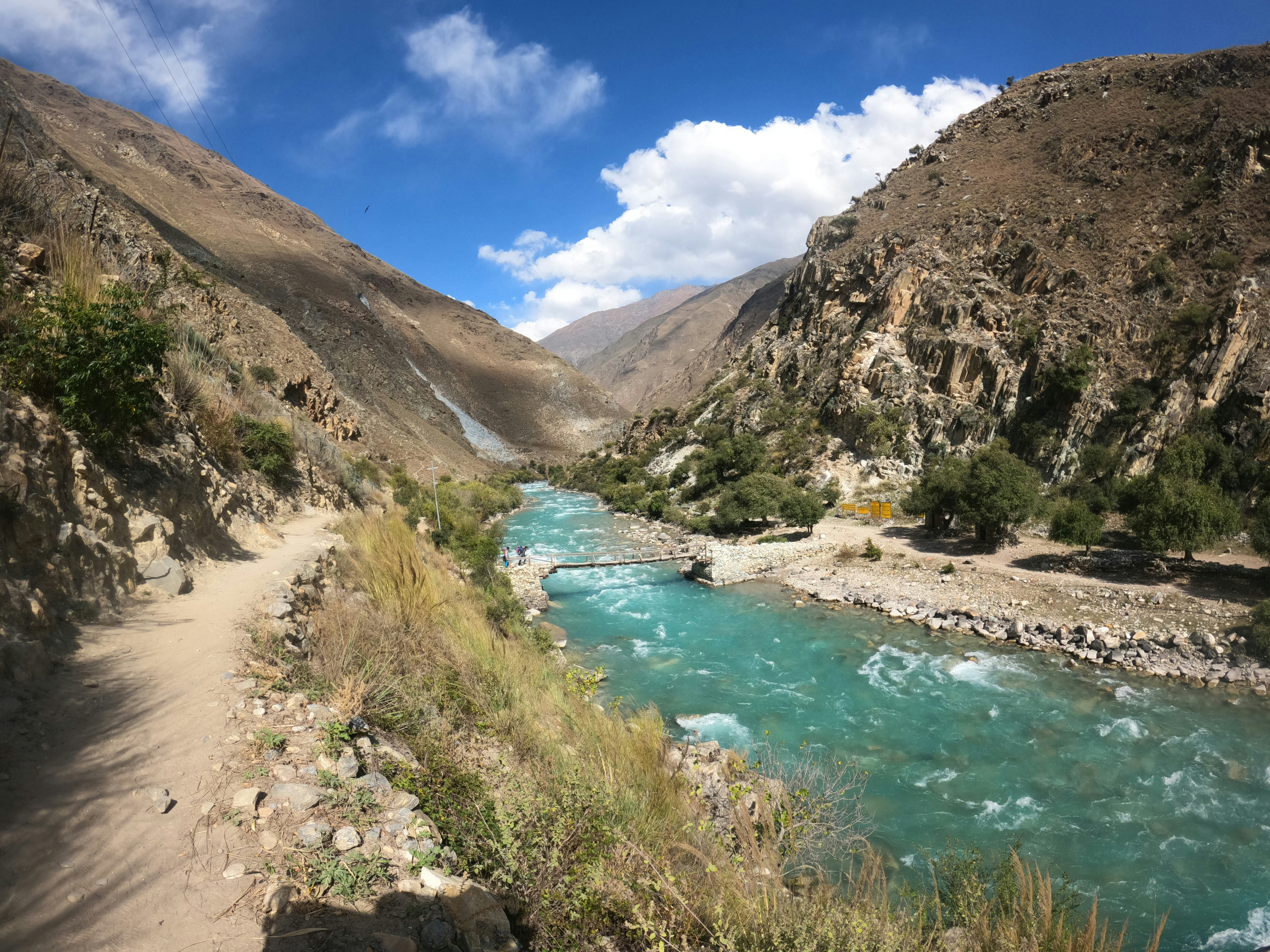 A river running through a valley surrounded by mountains photo – Free ...