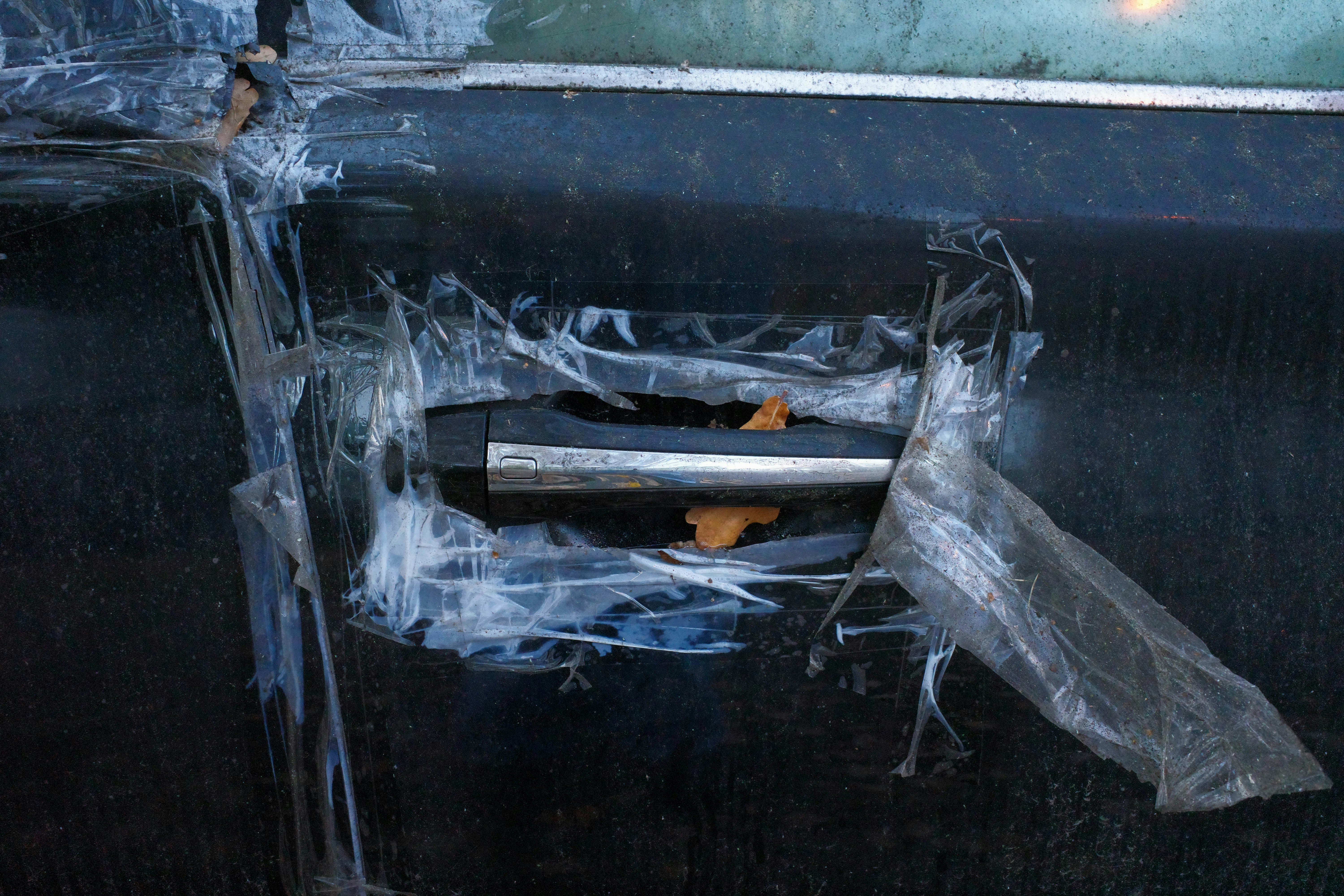 Close-Up: Plastic Wrap Framing a Damaged Car Panel