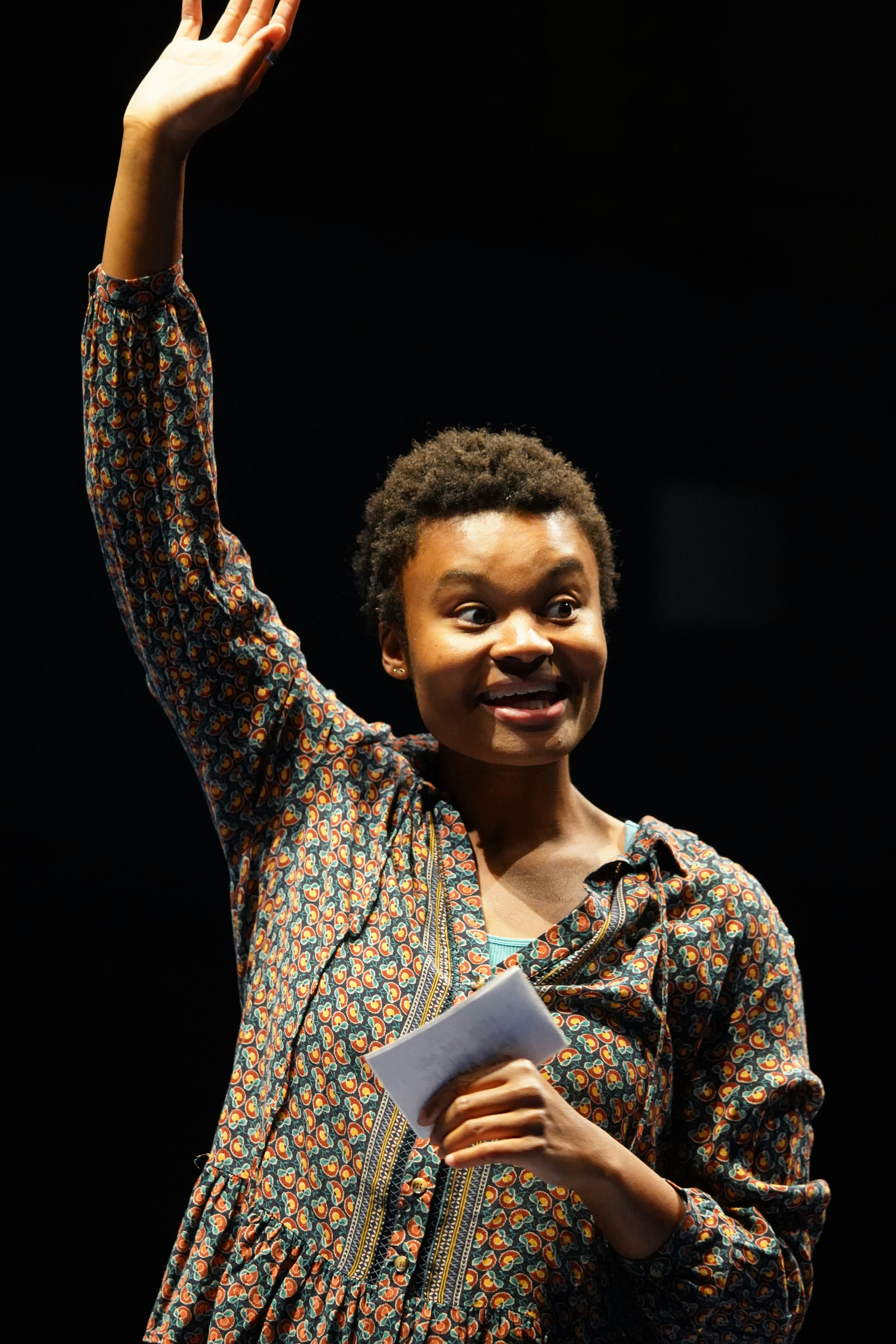 Raised Hand, Confident Presenter: A Moment on Stage