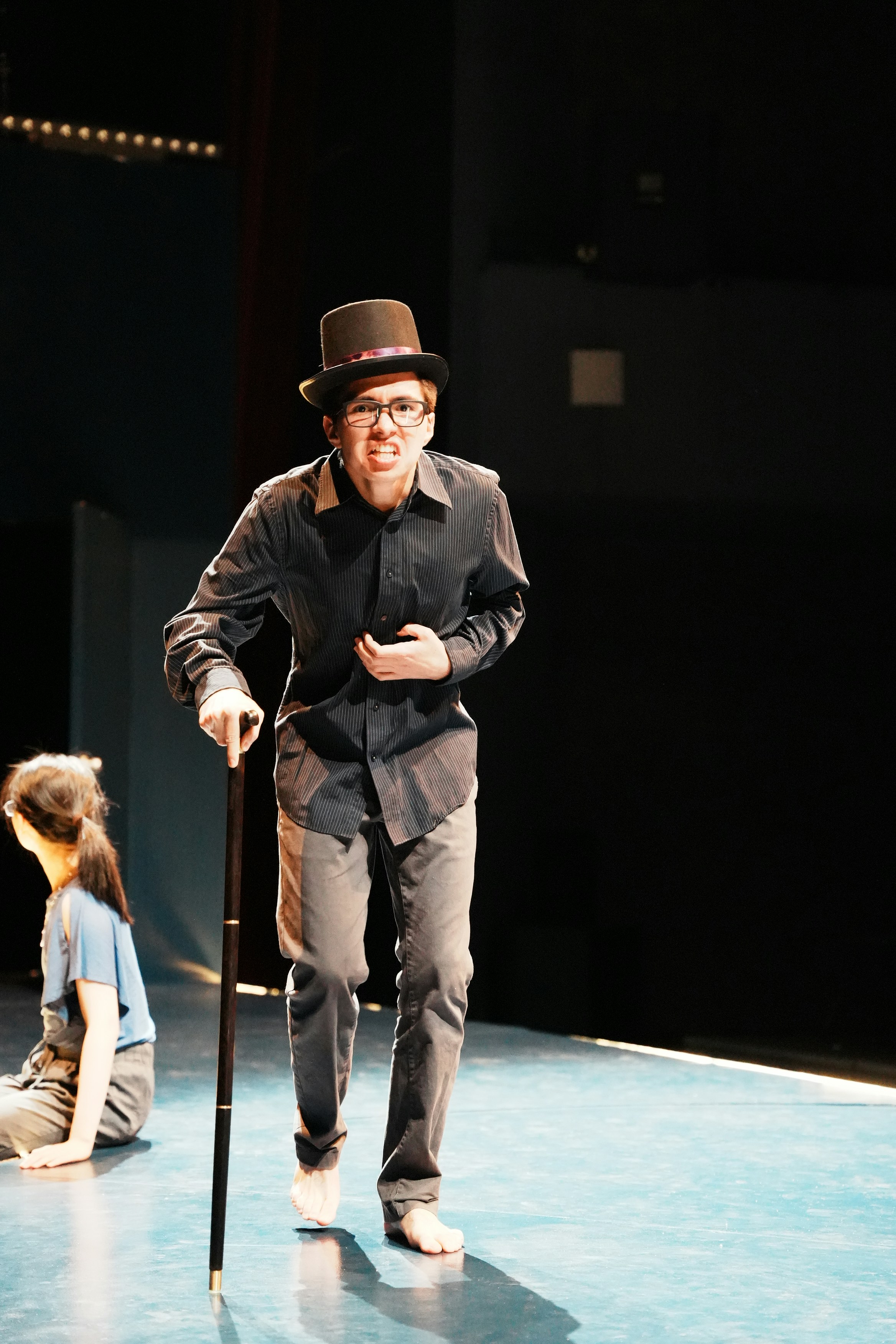A man standing on a stage holding a cane photo – Free Image on Unsplash