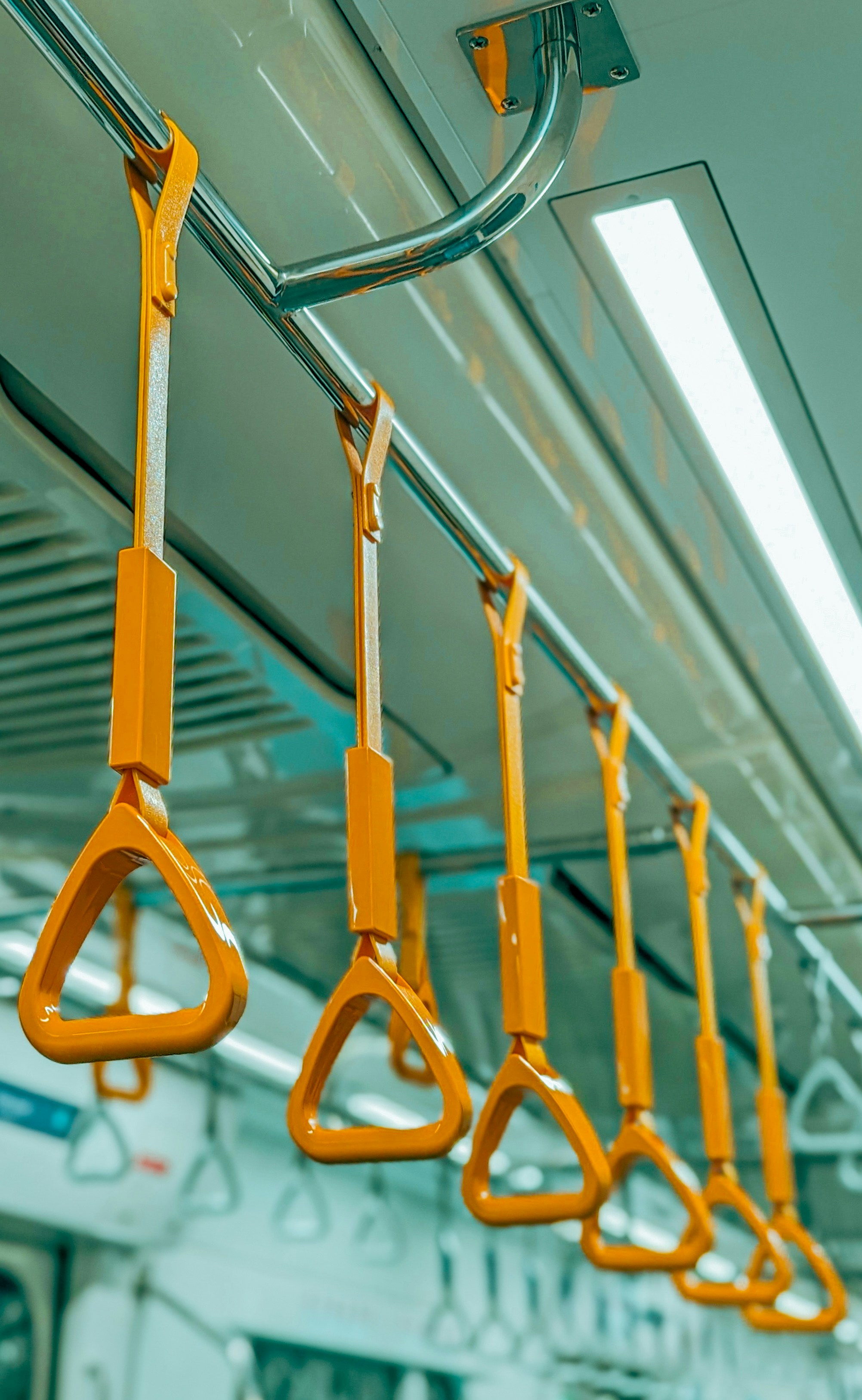 A row of orange handles hanging from a ceiling photo – Free Mrt jakarta ...