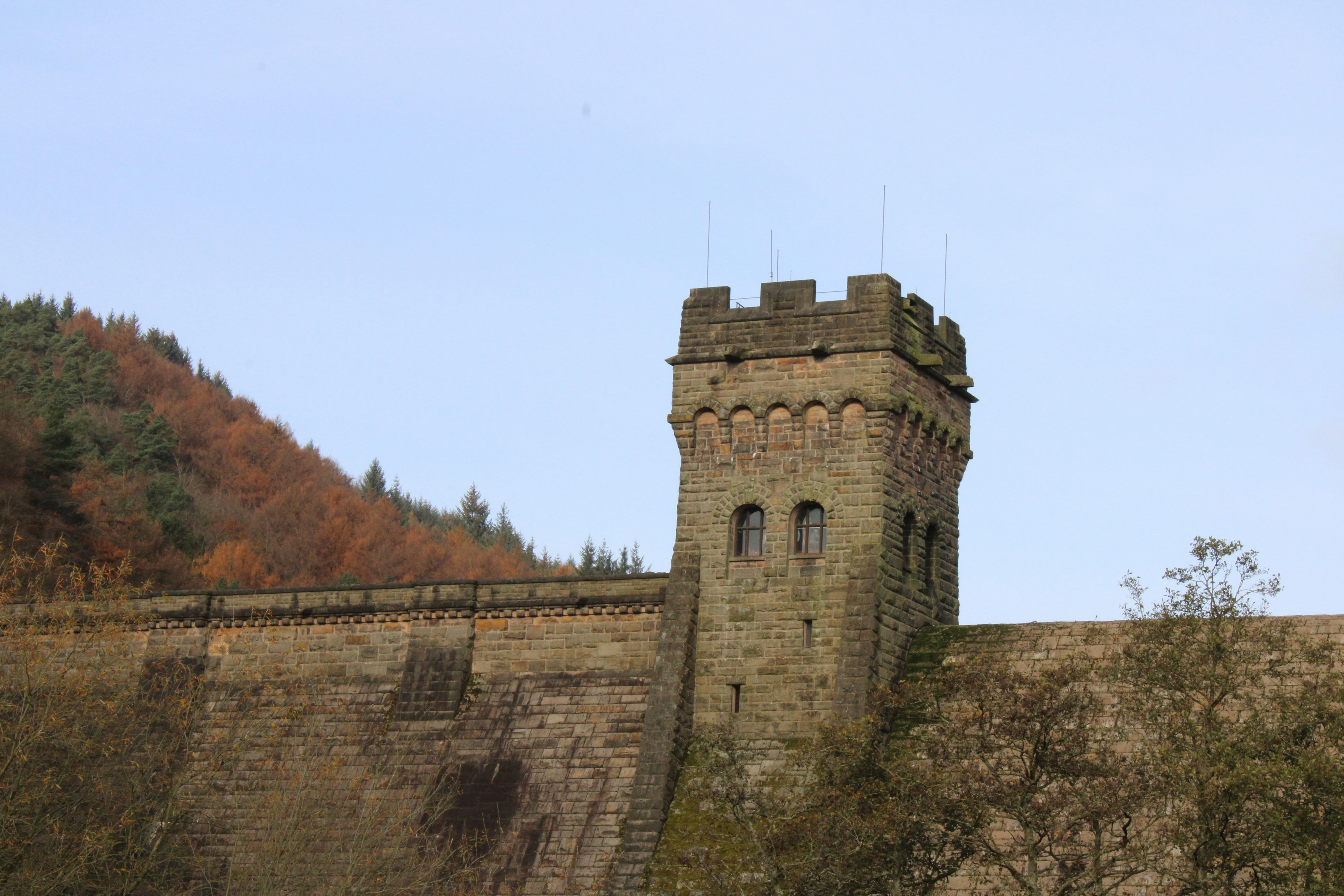 A tall brick tower sitting on top of a lush green hillside photo – Free ...