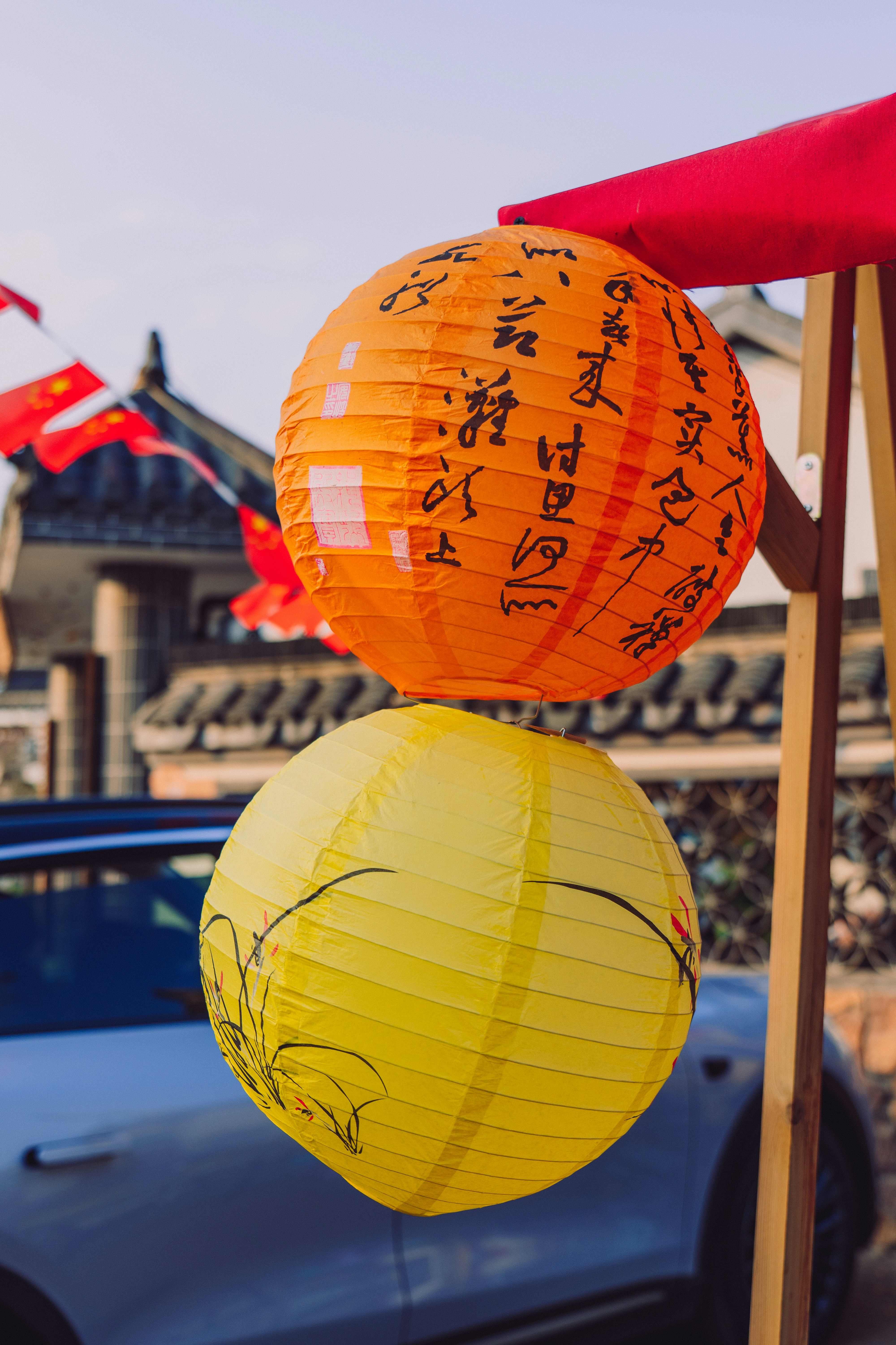 Lanterns in Motion: Orange and Yellow Orbs Against a Quiet Street
