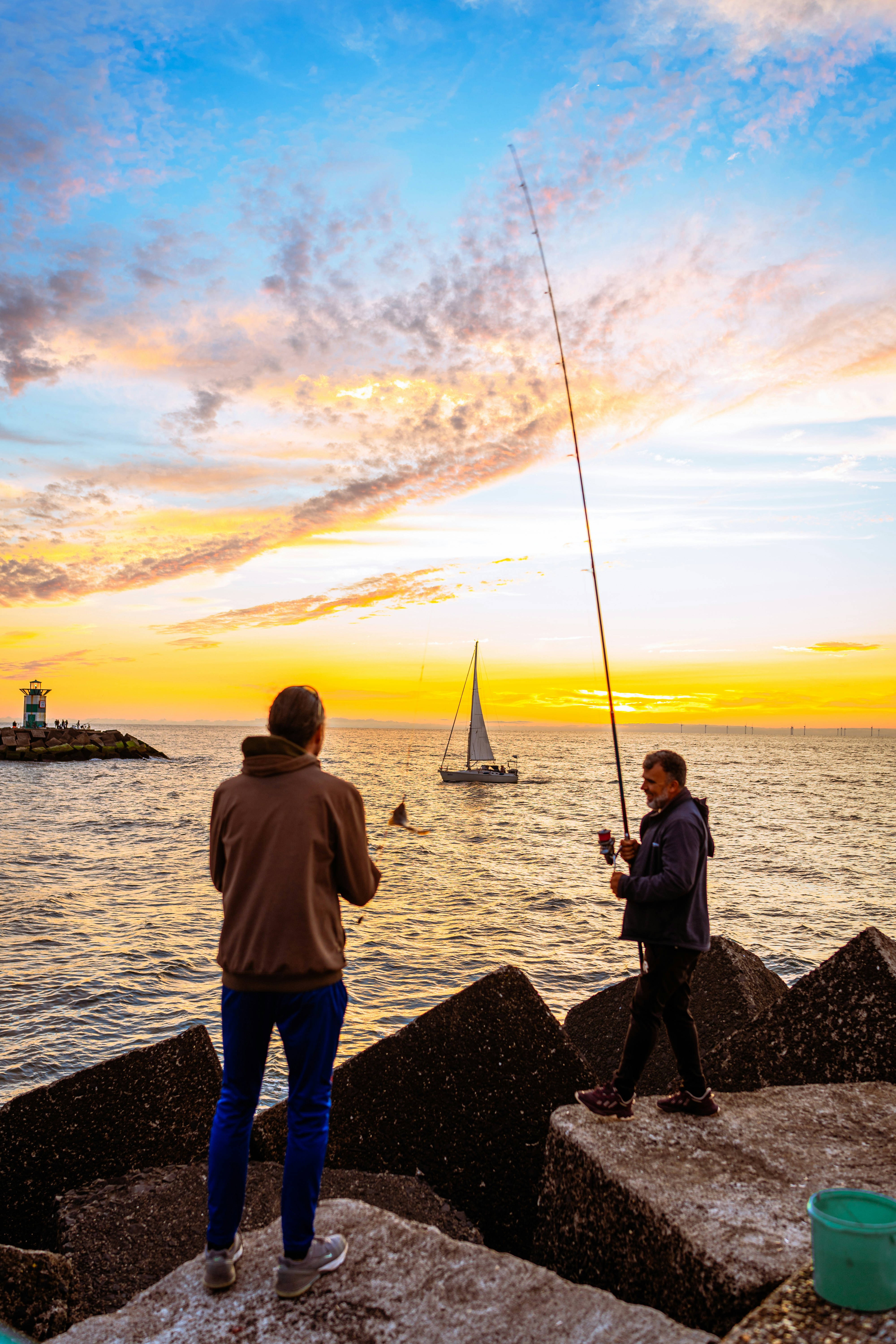 Dusk by the Breakwater: Two Fishermen in a Quiet Maritime Moment