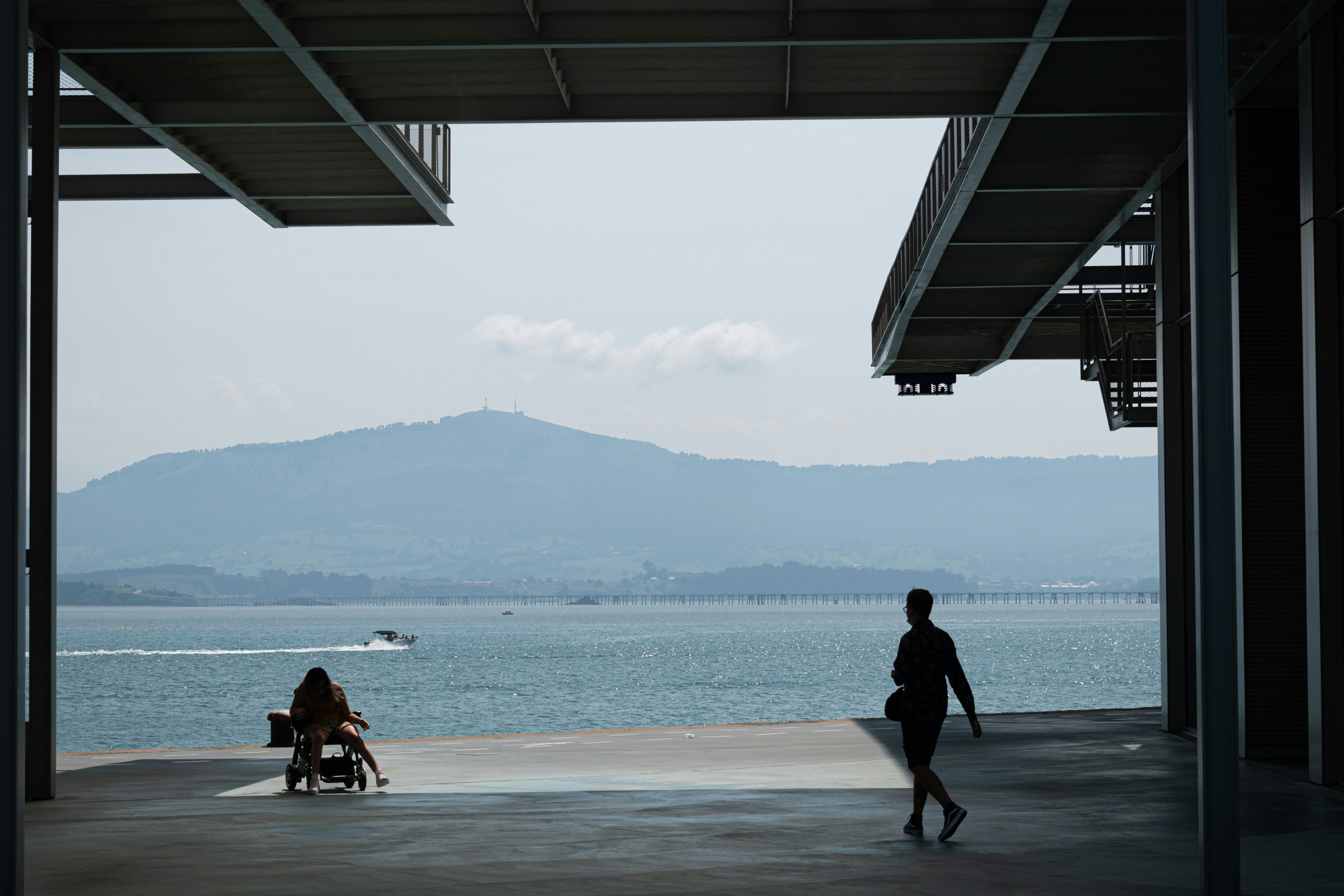 Shadowed Walkway by the Sea: Figures in a Framed Horizon