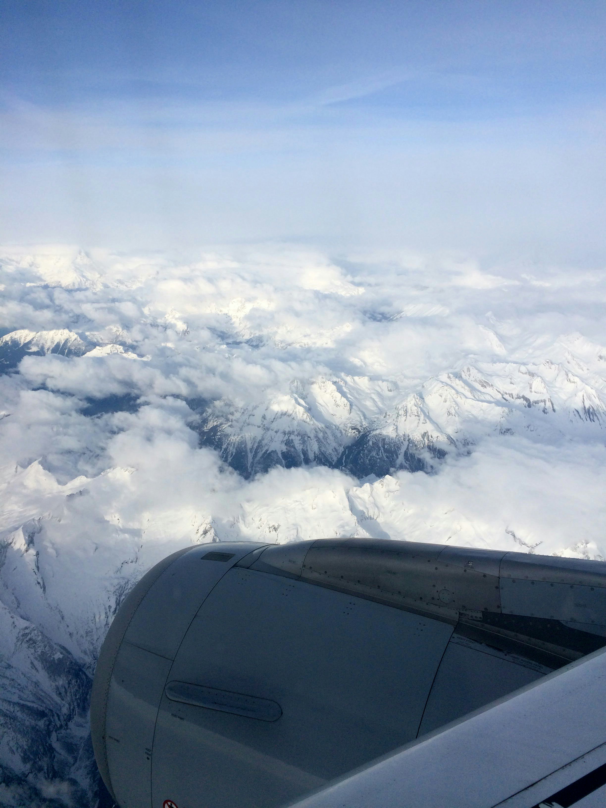 Wing and Engine Framing a Sea of Snow-Capped Peaks