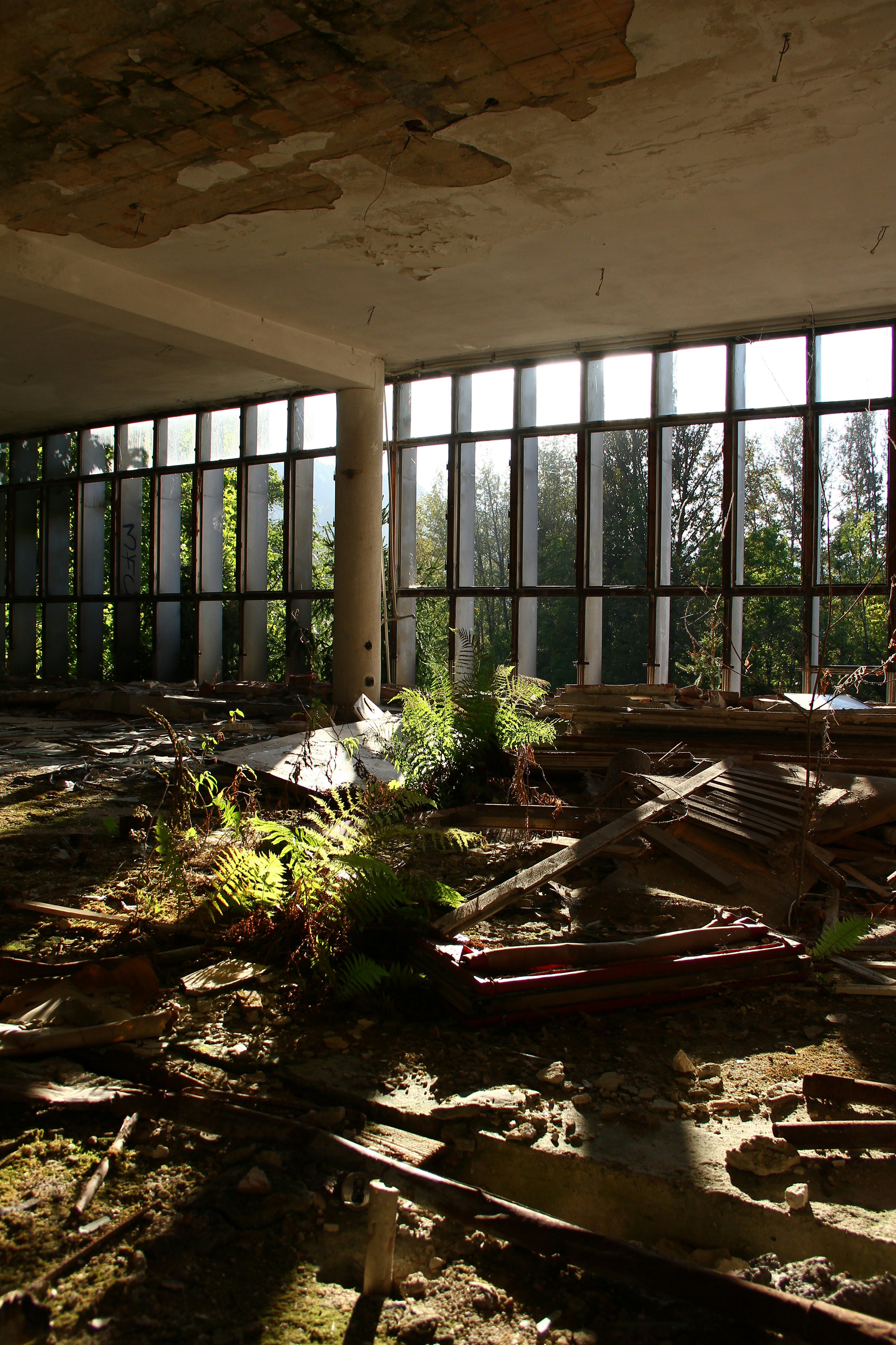 An abandoned building with lots of windows and debris photo – Free ...