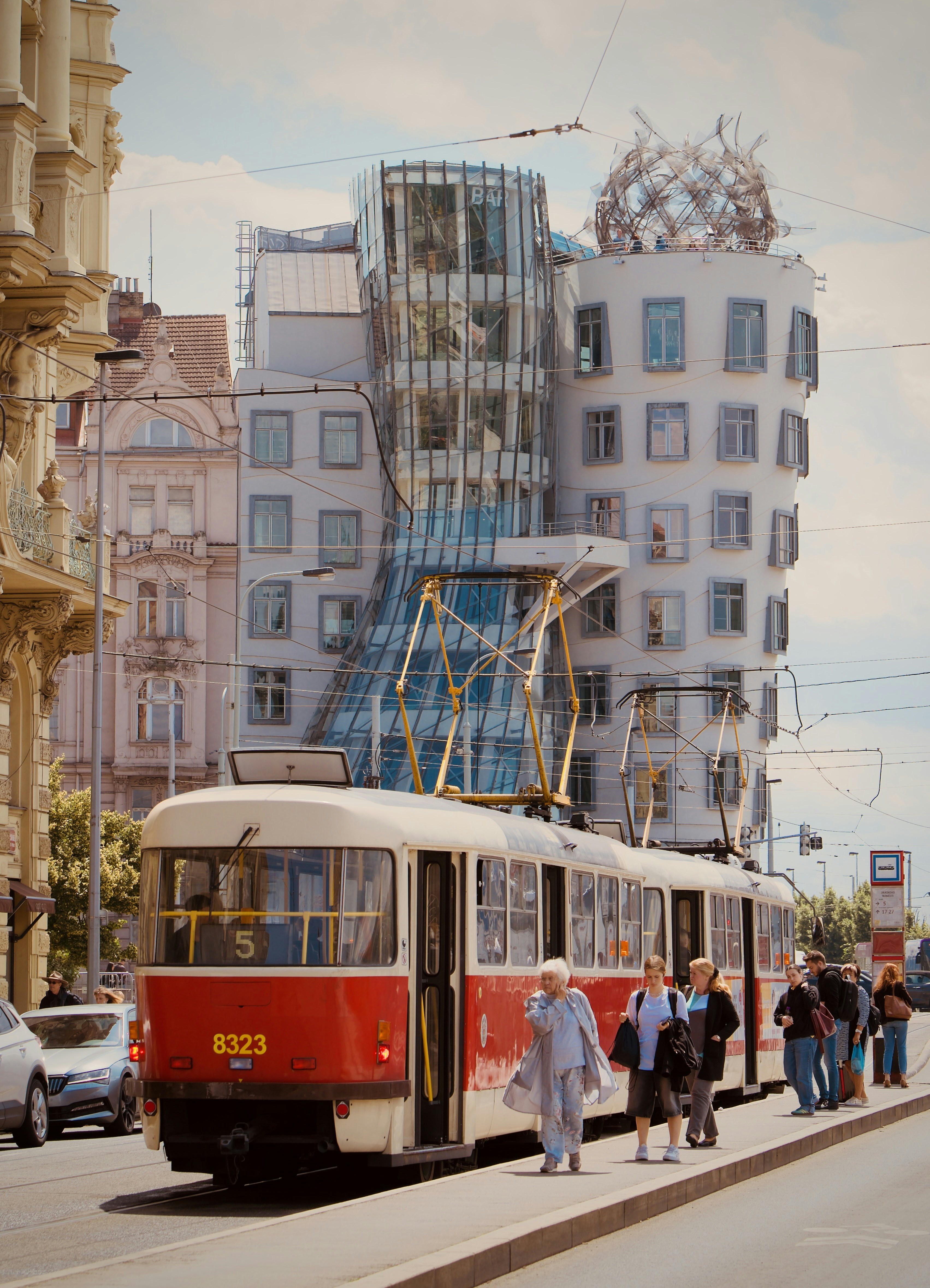 Red Tram at the Bend: Vintage Carriage Meets the Dancing House