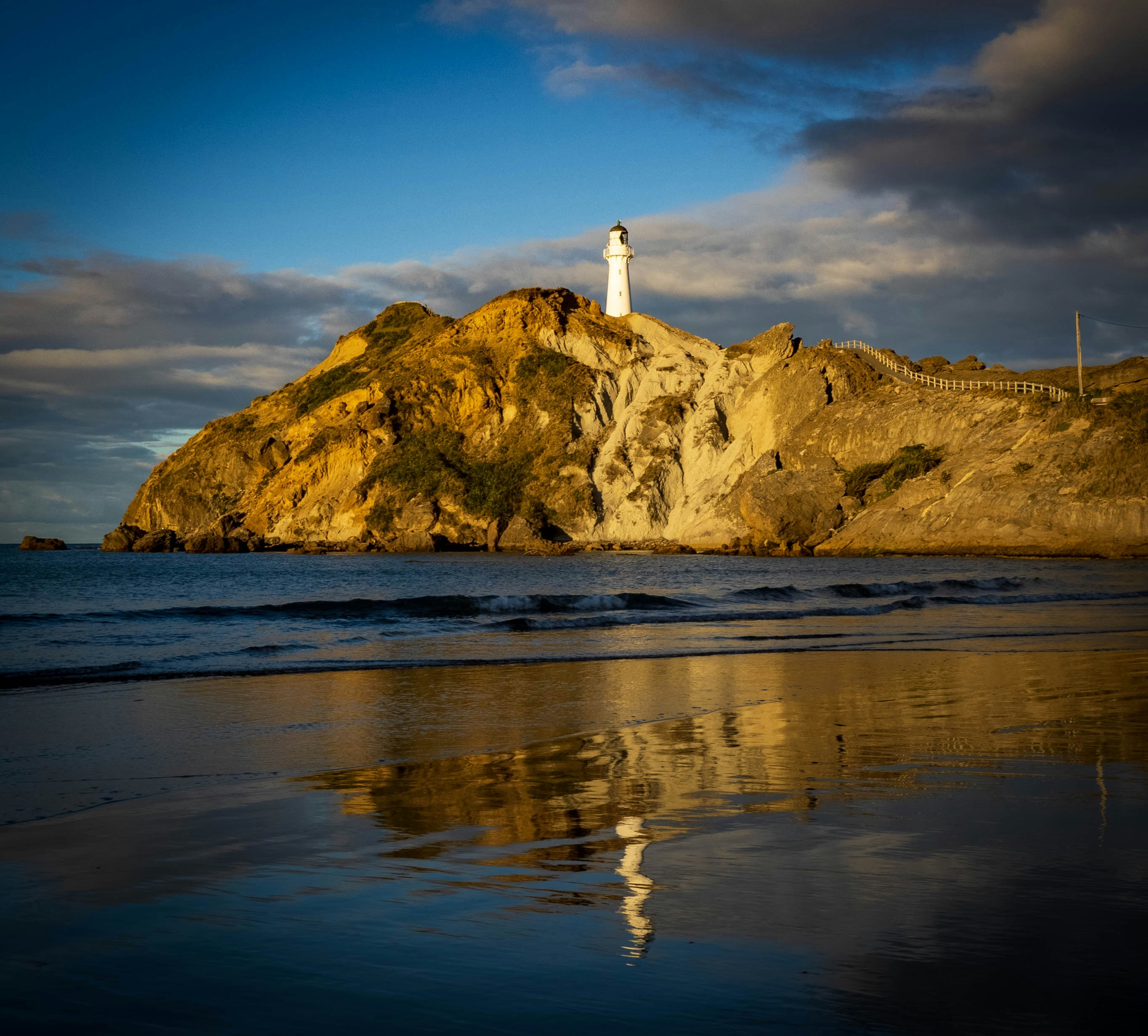 Beacon on a Sunlit Cliff: Reflections Across a Quiet Shore