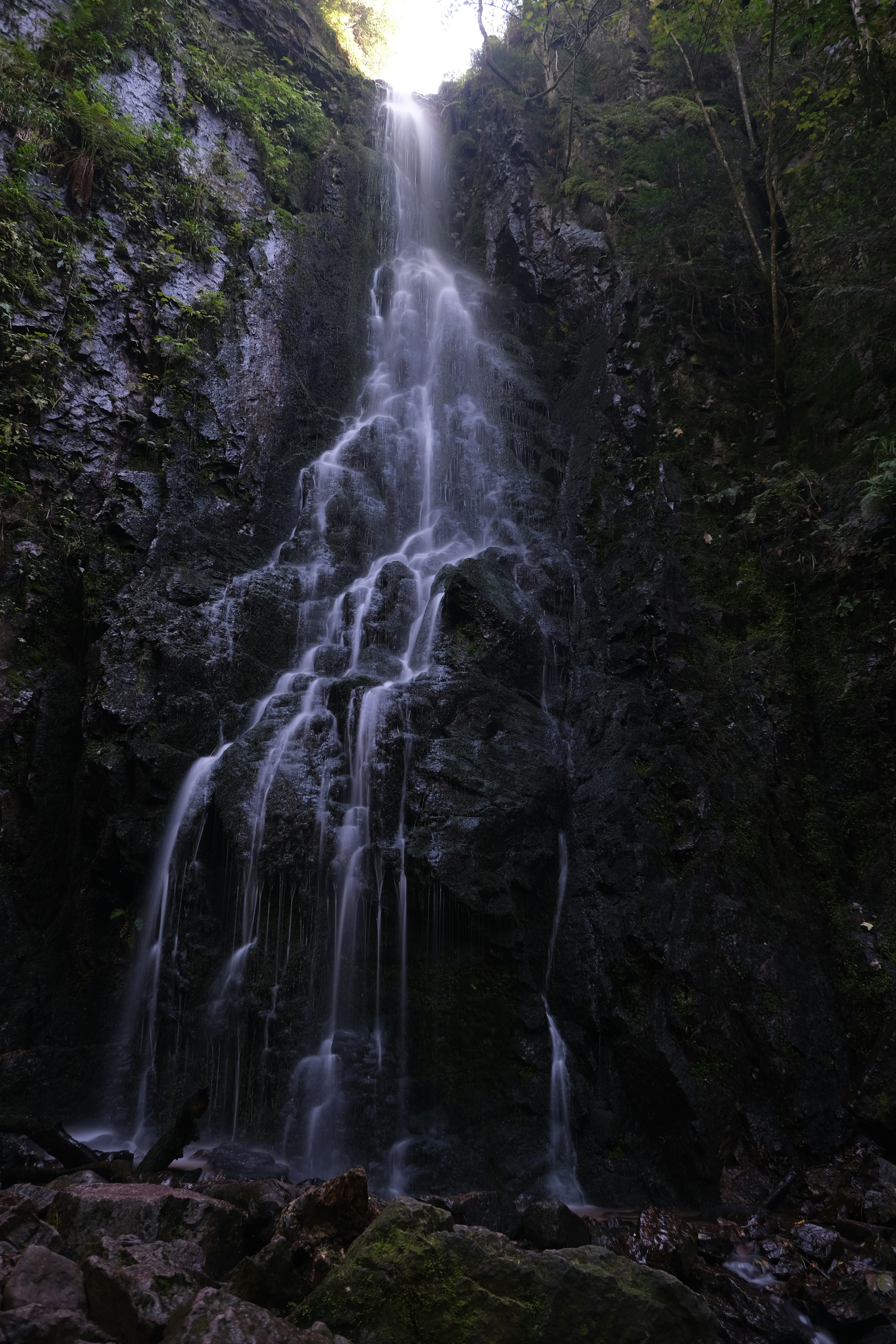 A very tall waterfall in the middle of a forest photo – Free Natur ...