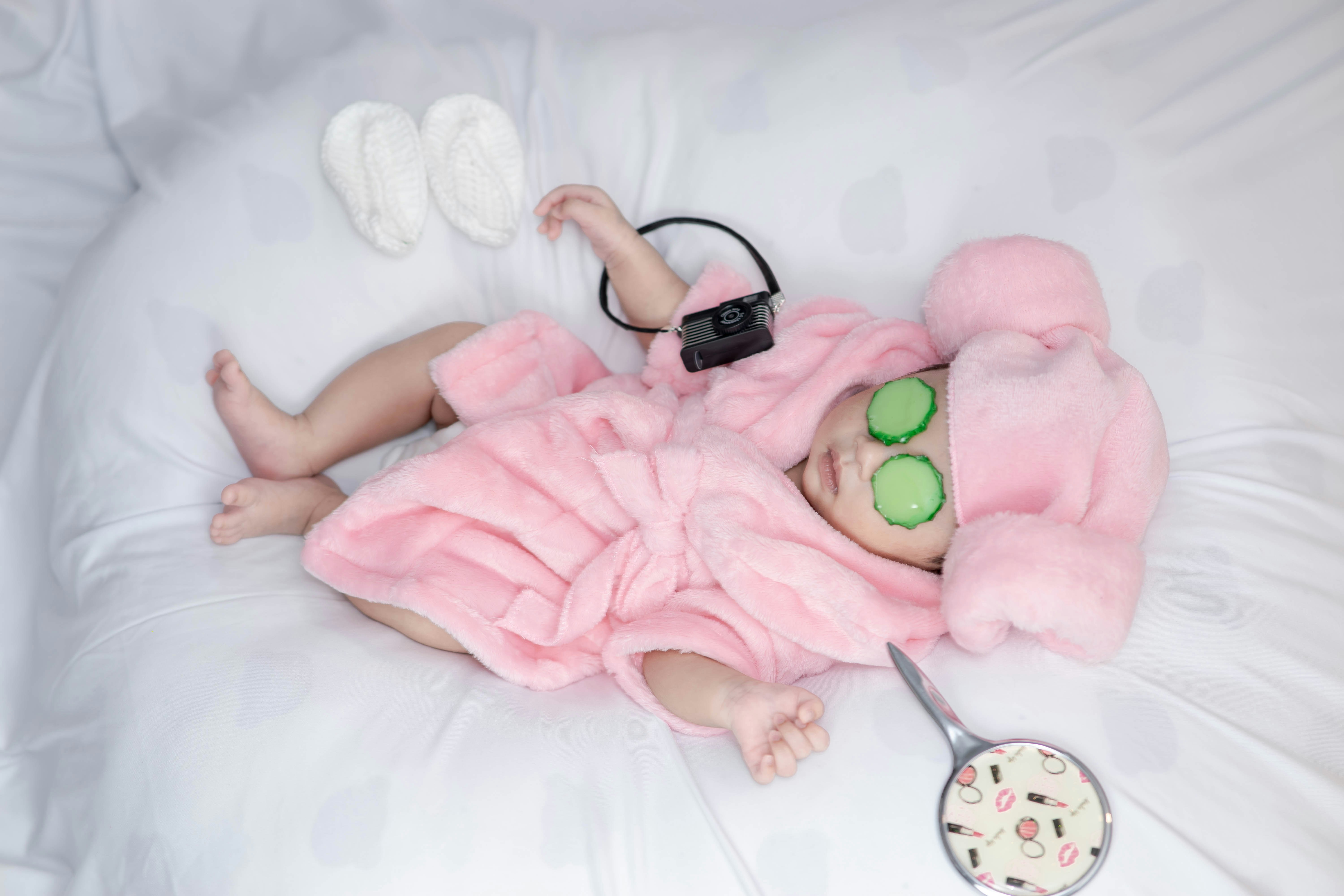 Fluff and Focus: A Pink Plush Baby Lounges with a Mini Camera