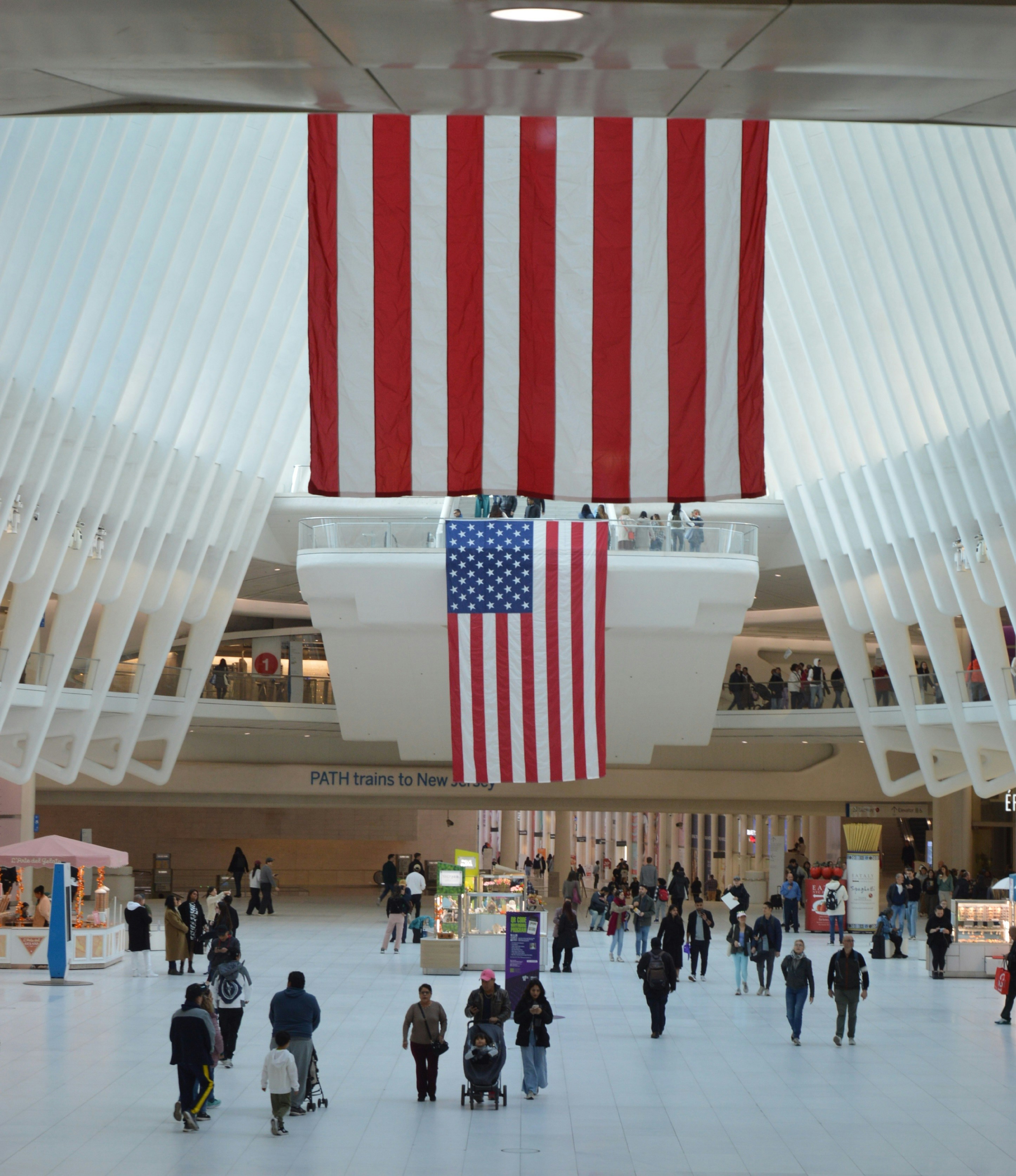 Flag Over the Atrium: Red Stripes Amid White Pillars