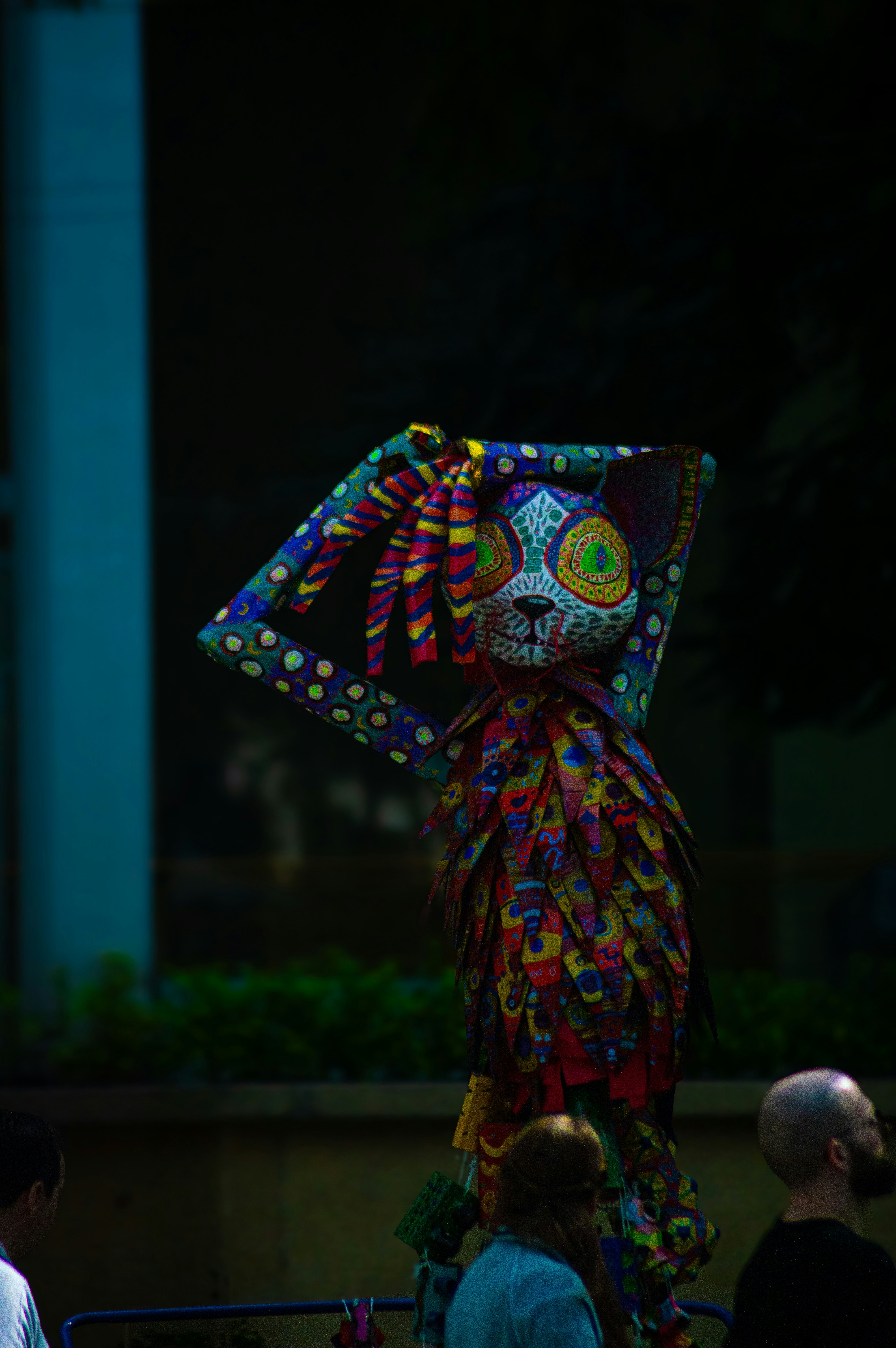 Colorful Kinetic Mask Parade Under Dim Streetlight
