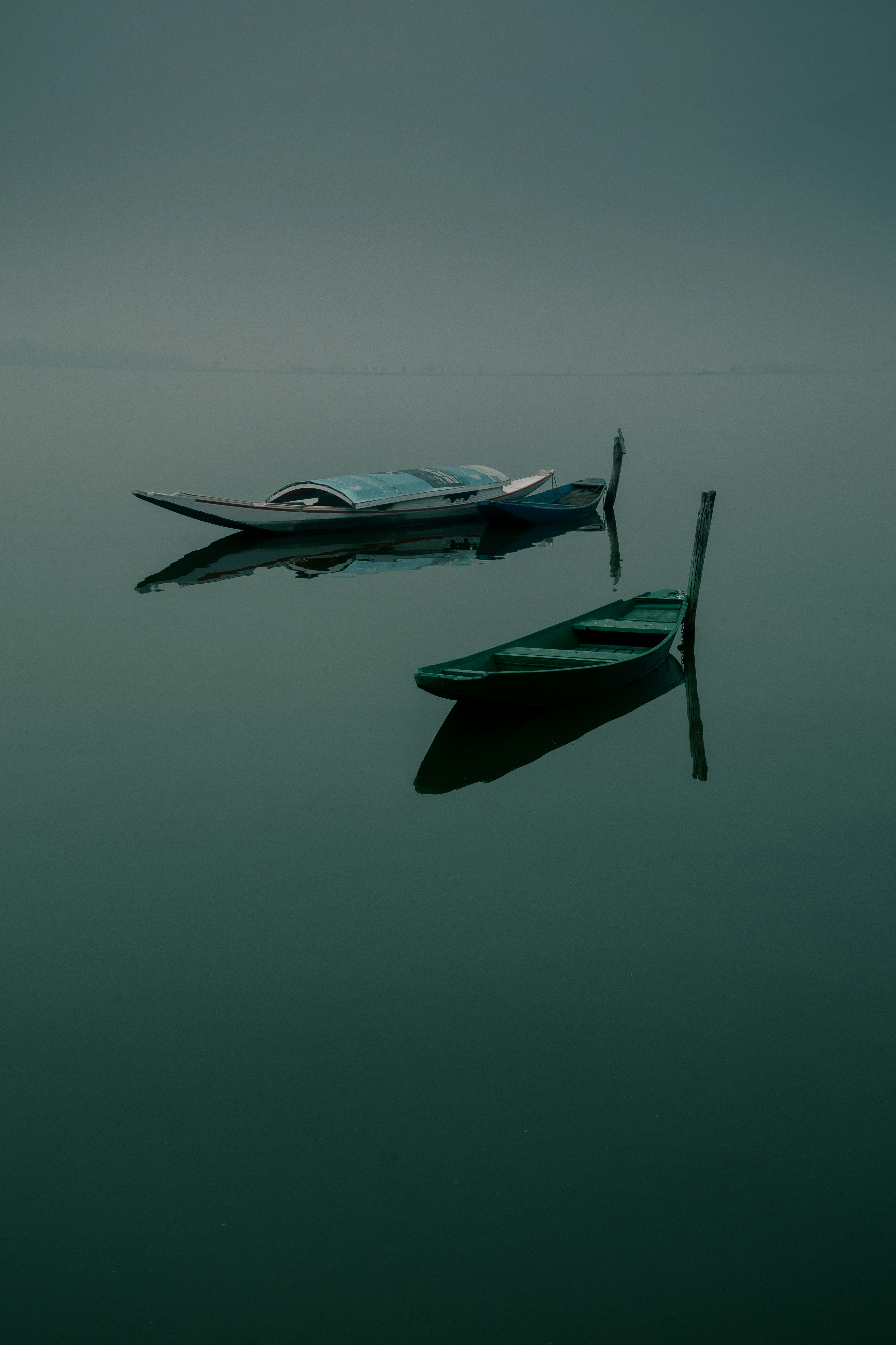 Two small boats floating on top of a body of water photo – Free Sea ...
