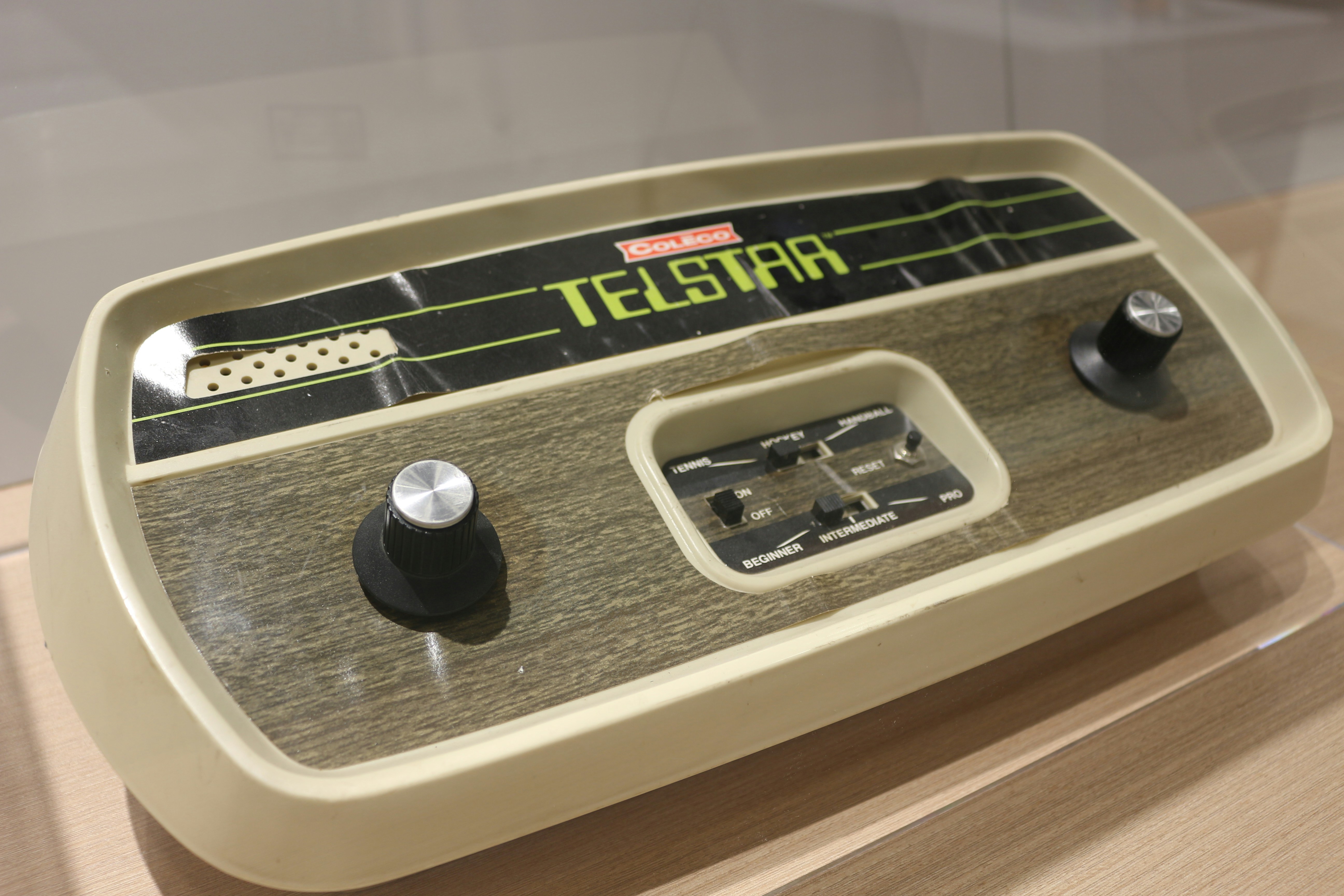 Vintage Telstar console with wood veneer and dual chrome knobs on a display stand, featuring the Telstar logo.
