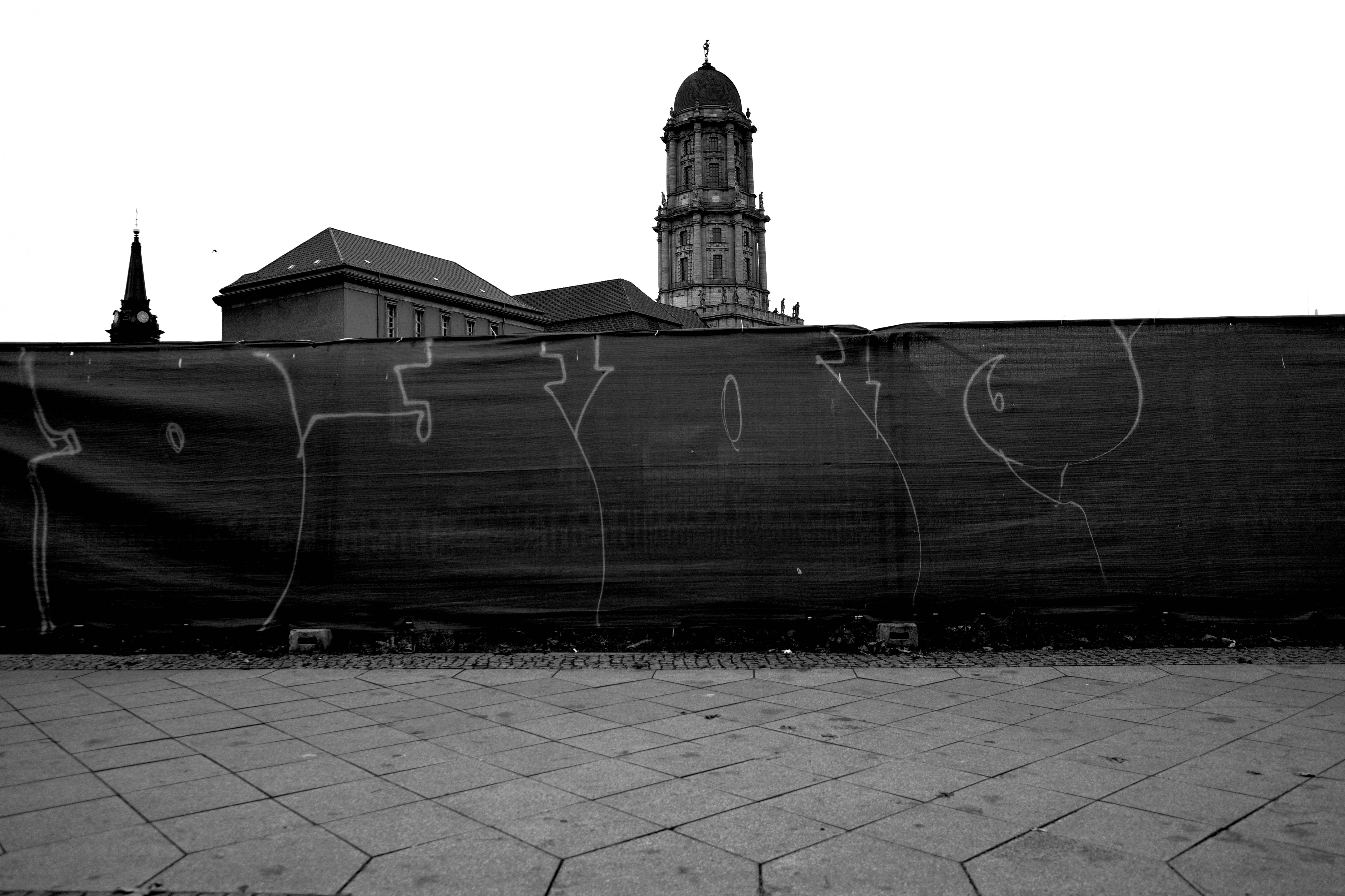 Tower in Focus Behind a Graffiti Barrier