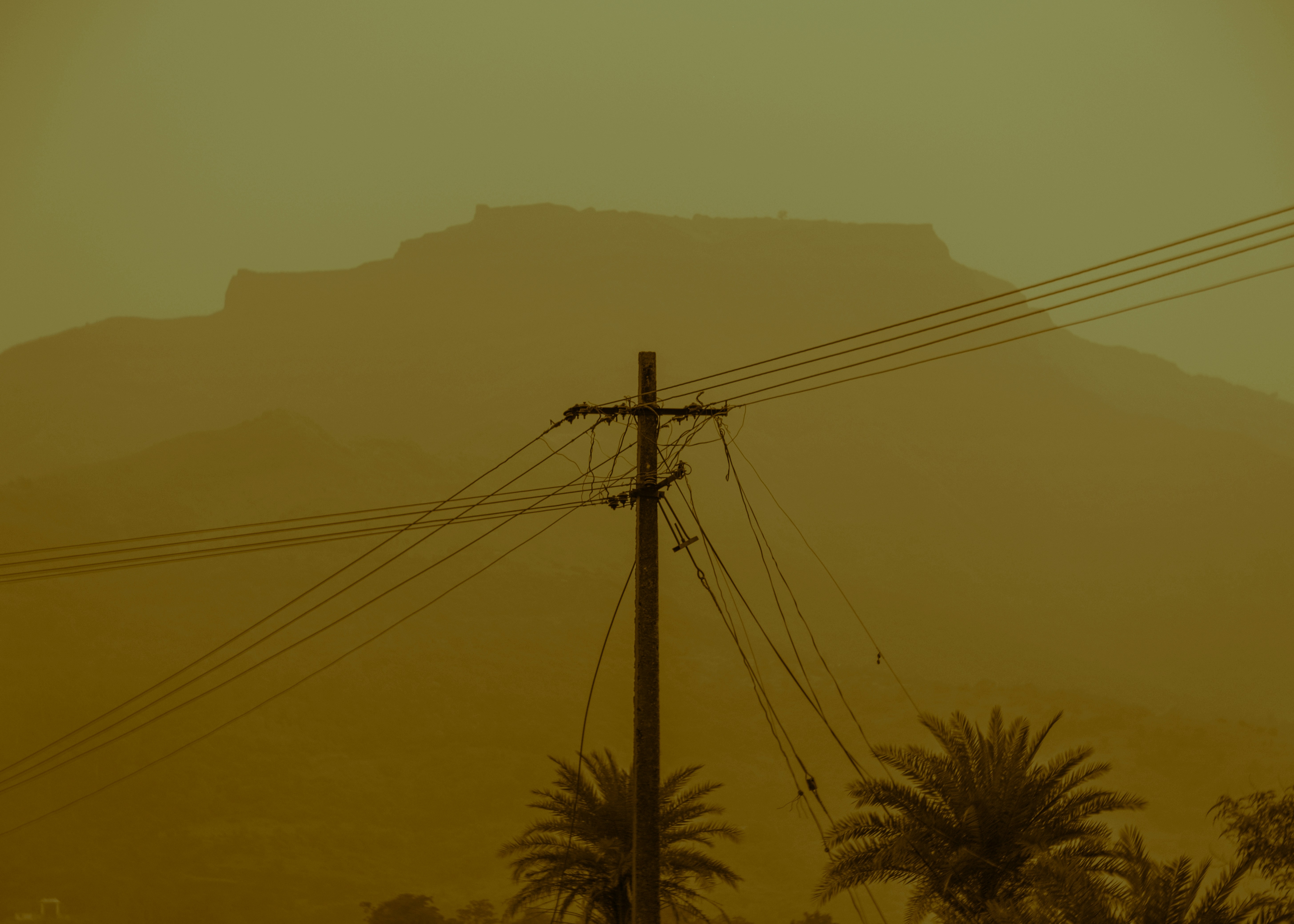 Hazy Desert Current: The Lone Power Pole Framing a Mesa Horizon