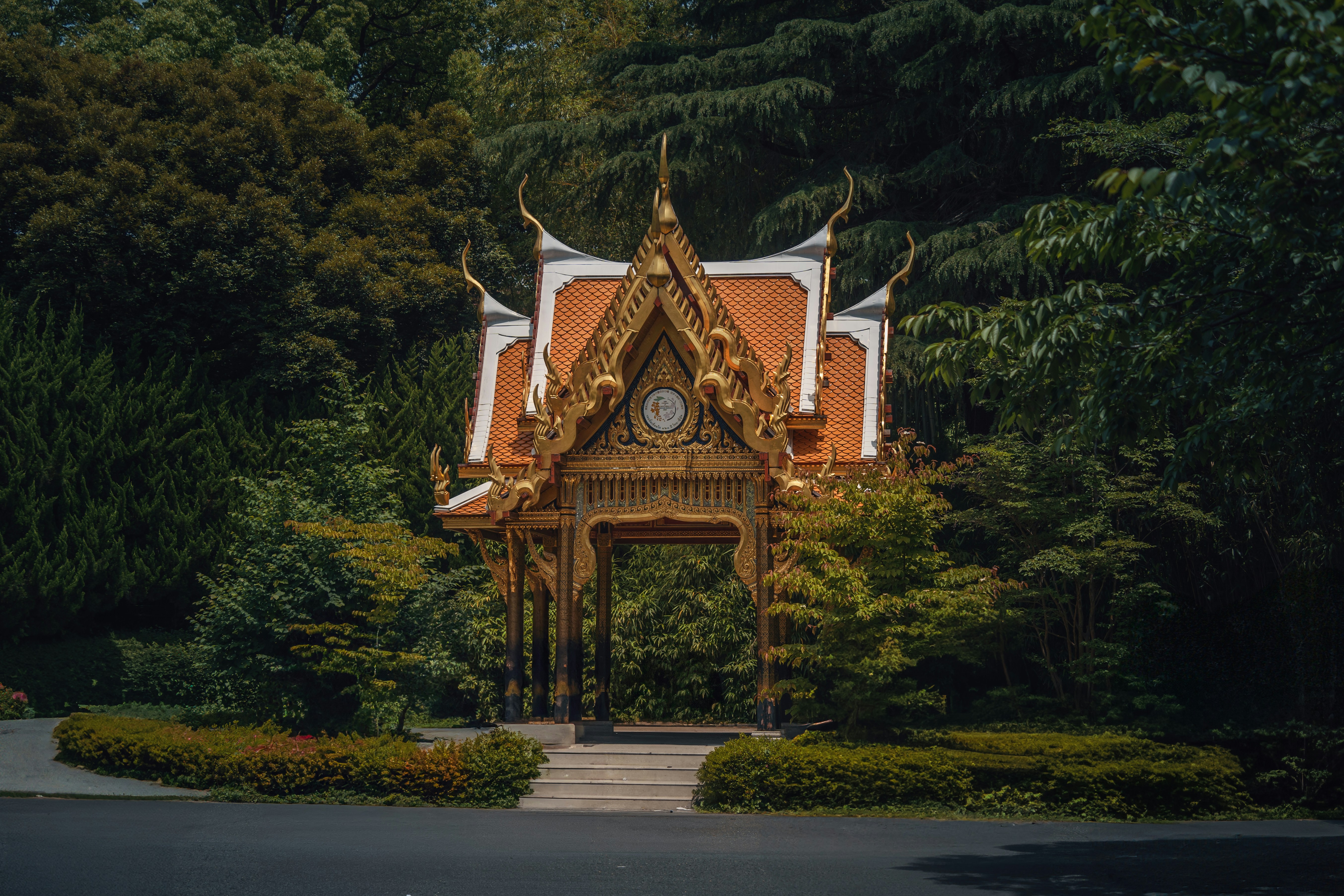 Gateway of Gold Roofs: An Ornate Temple Gate Amid Verdant Park