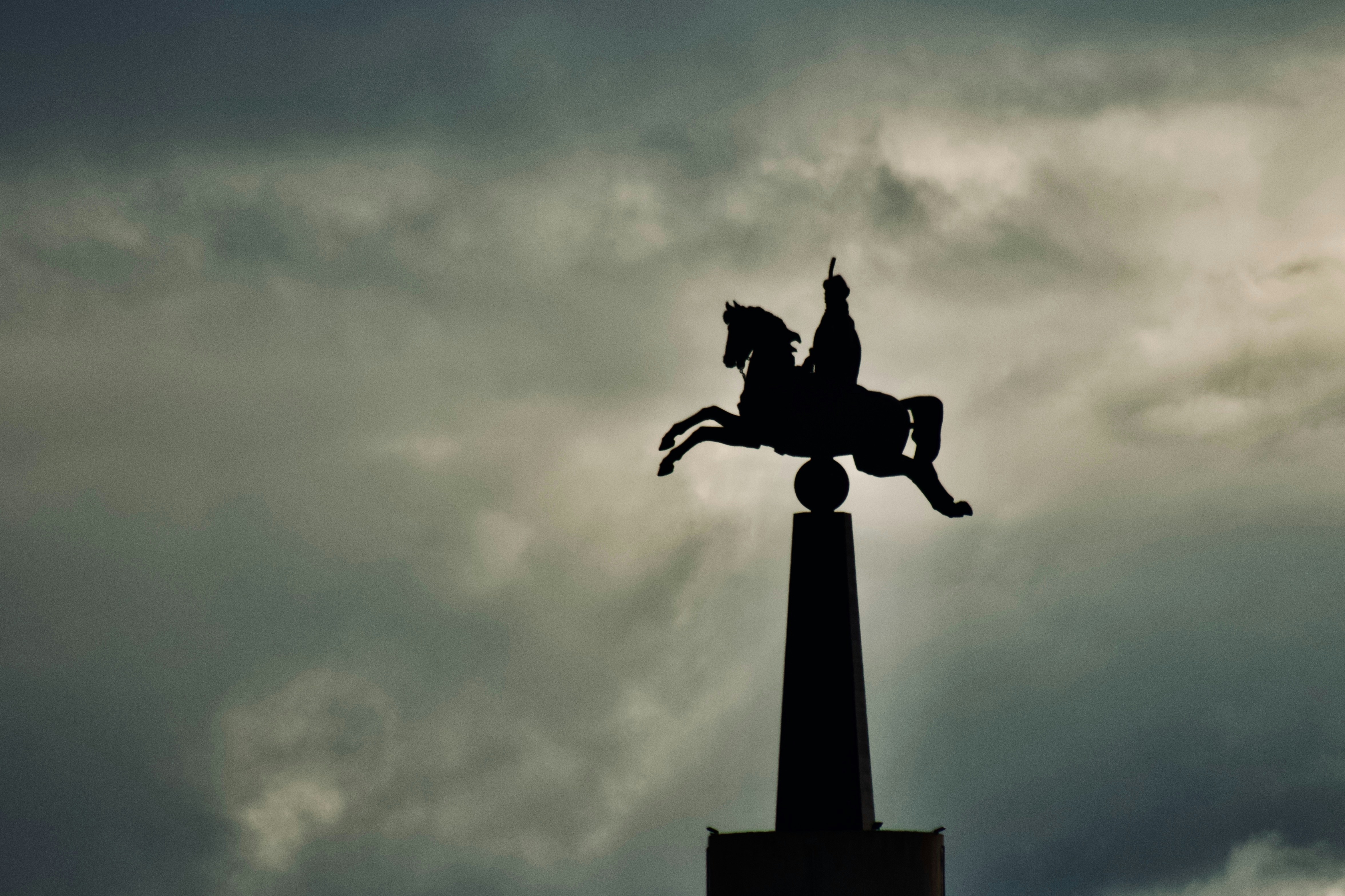 Silhouette of a Winged Horse Statue Against a Stormy Sky