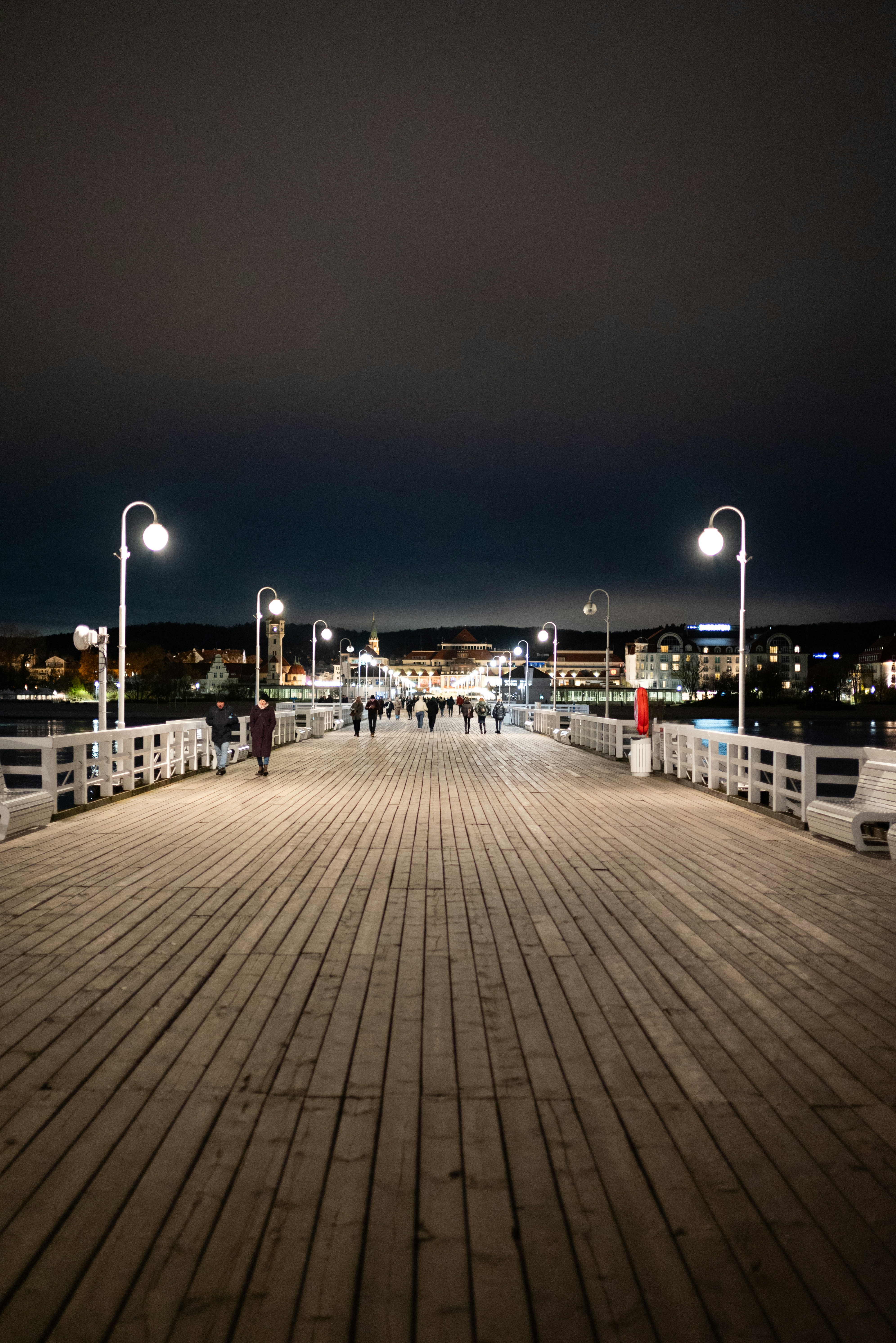 Midnight Promenade: Lanterns Line a Wooden Pier Toward a Quiet Harbor