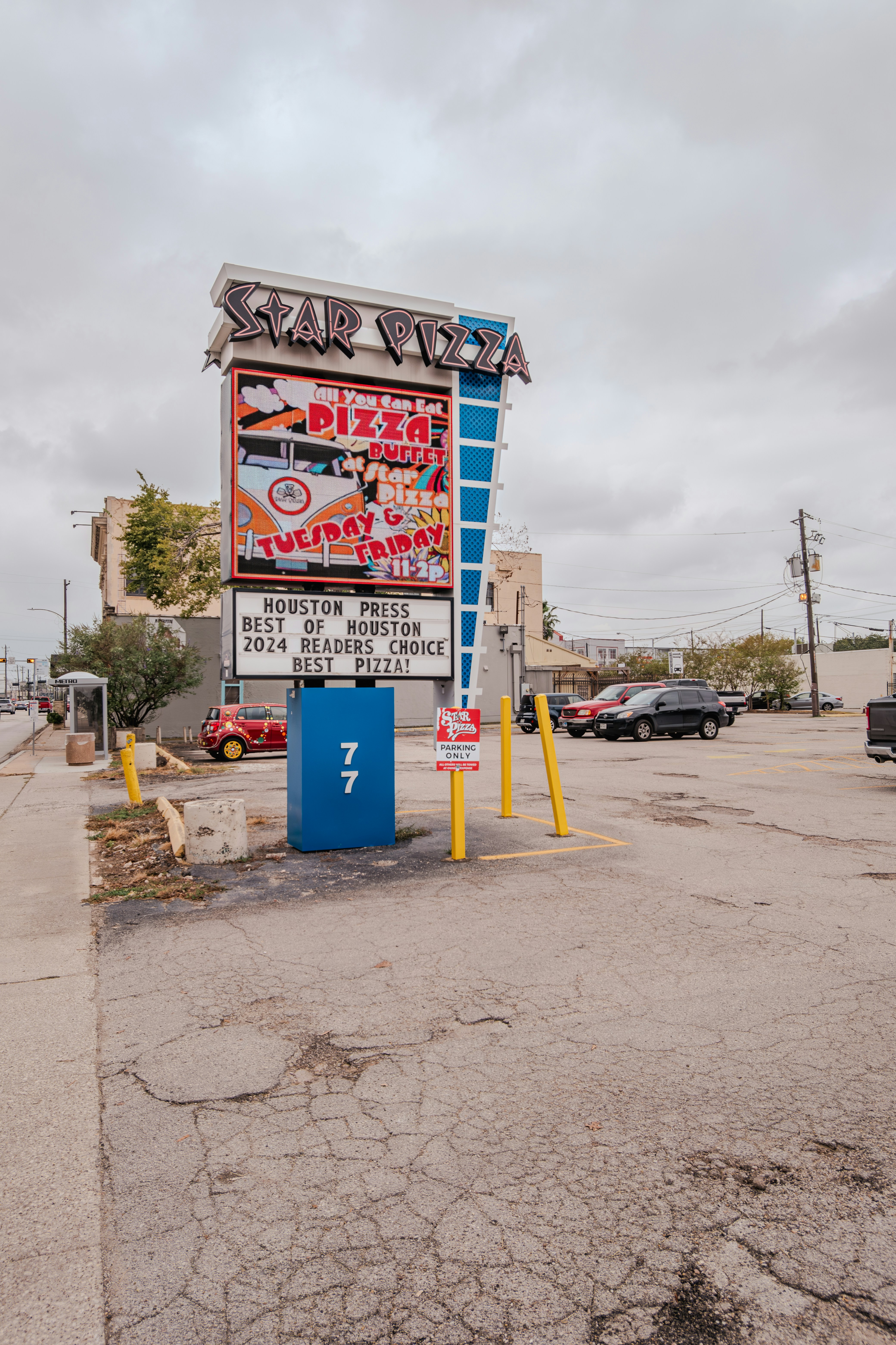 Neon Pizza Sign Above a Weathered Lot