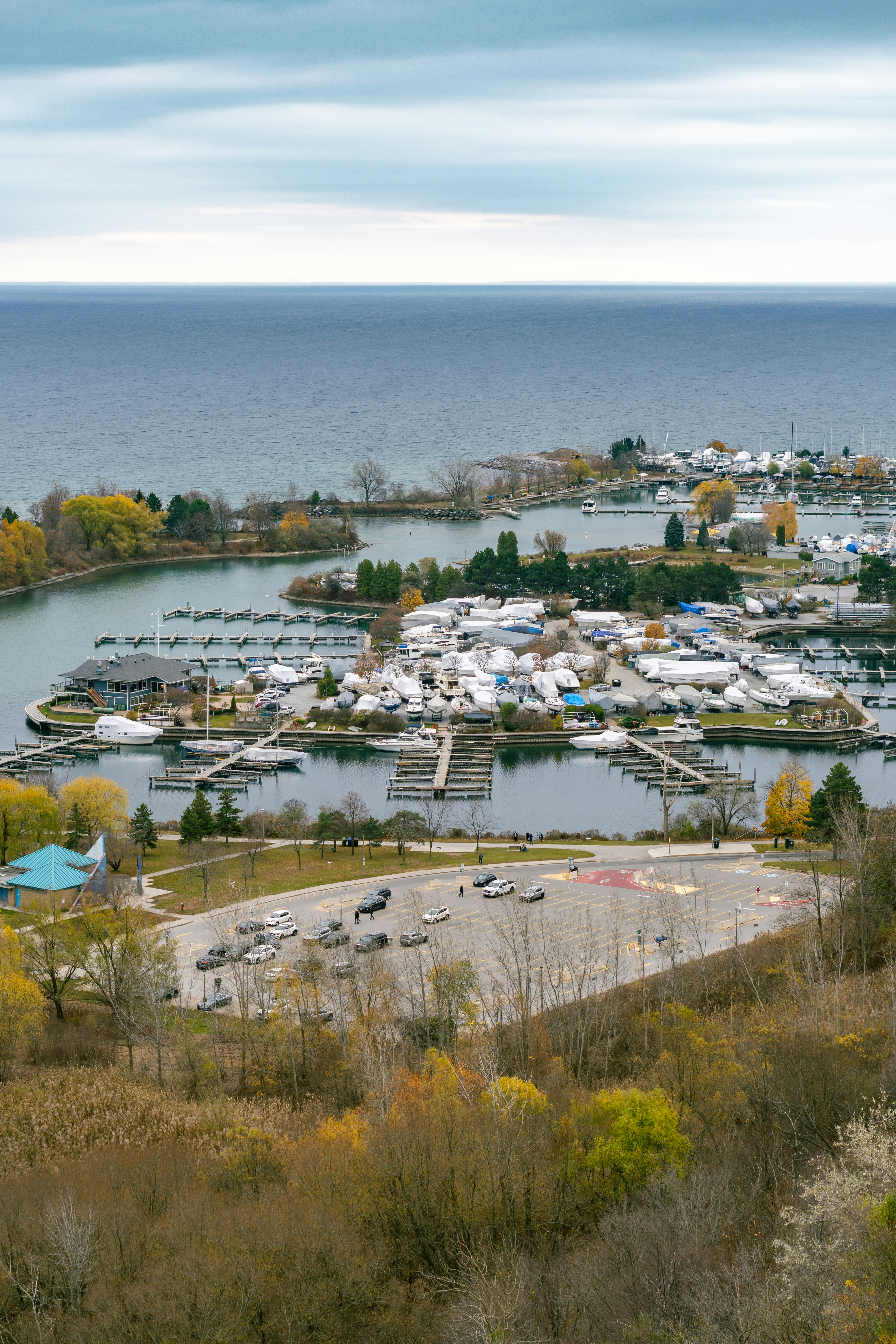 Marina Mosaic: Boats and Breakwater Fragments Nestle Along a Lakefront Harbor