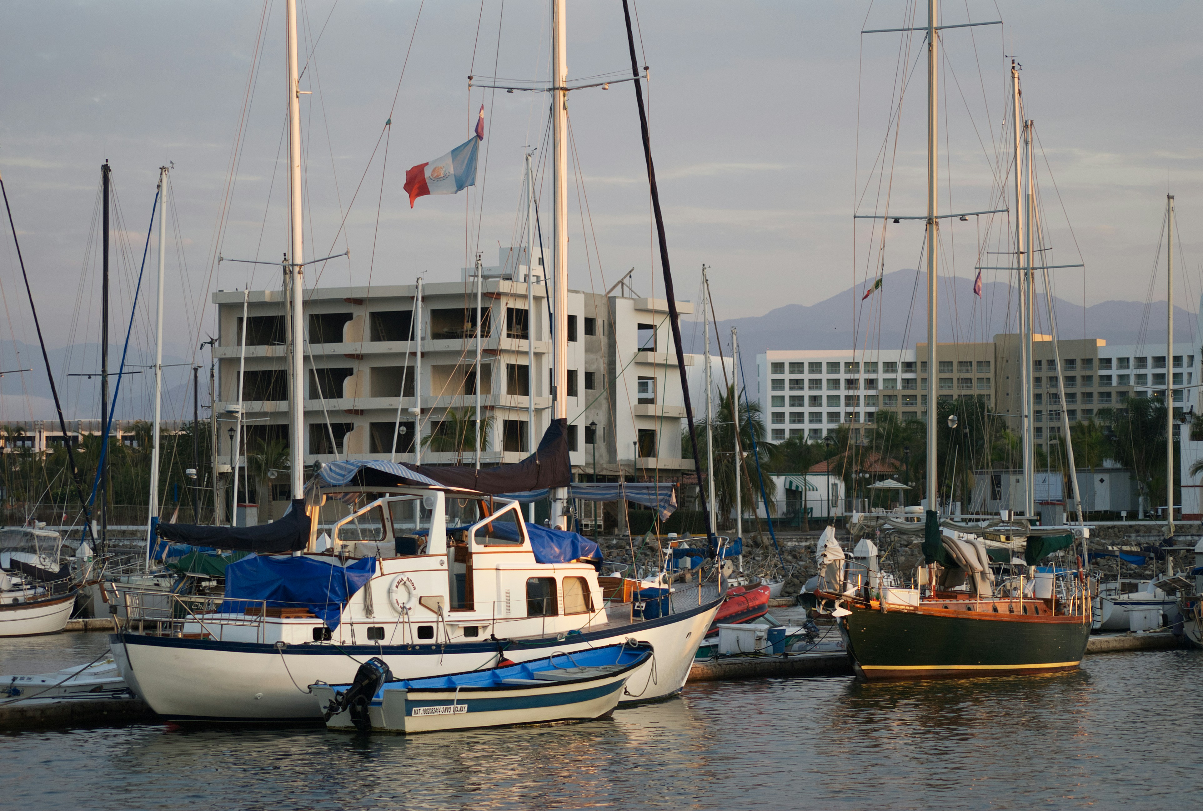 Dusk at the Marina: Sailboats Quietly Rest Against an Urban Waterfront