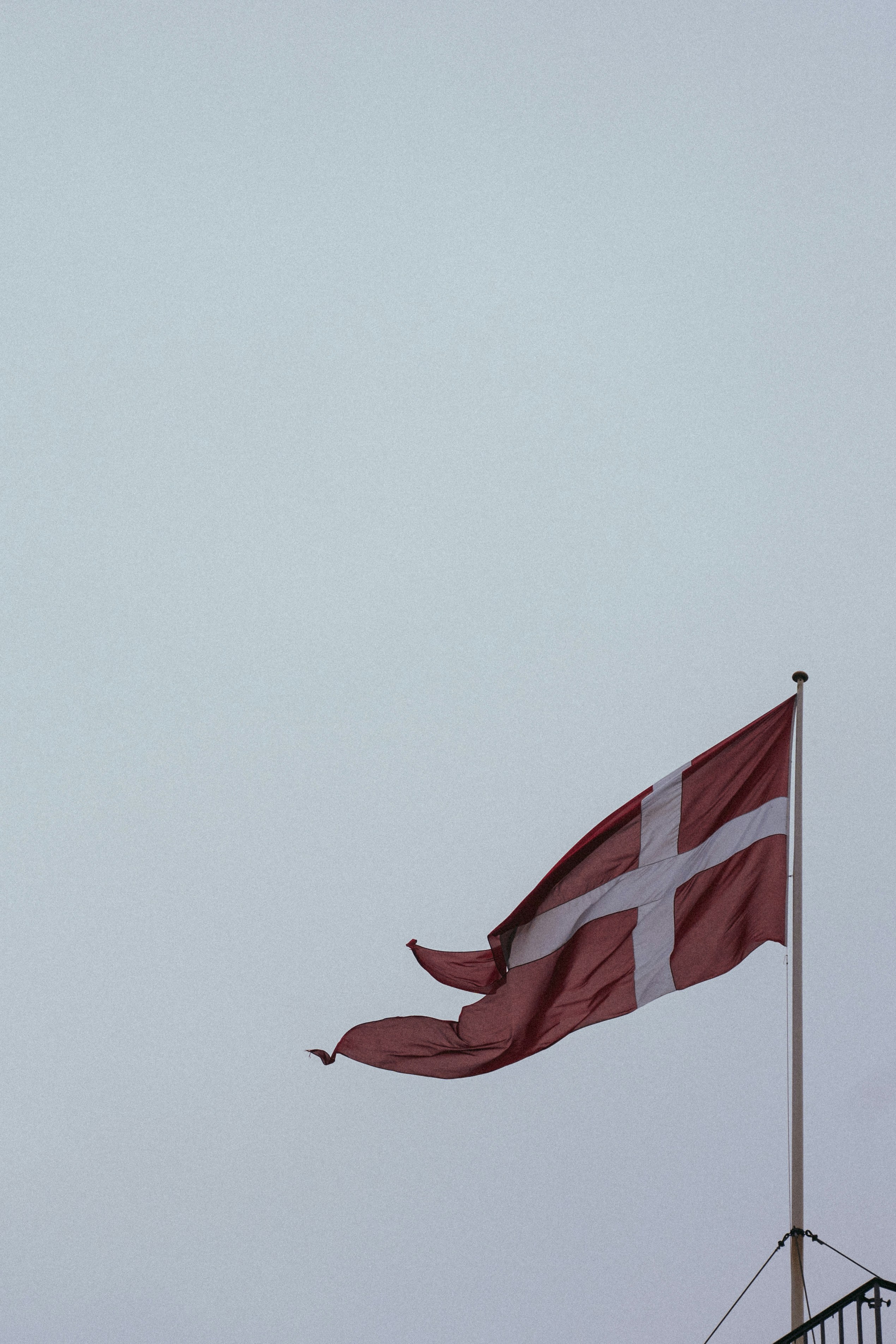 Danish Cross in the Wind: Flag at the Edge of a Quiet Sky