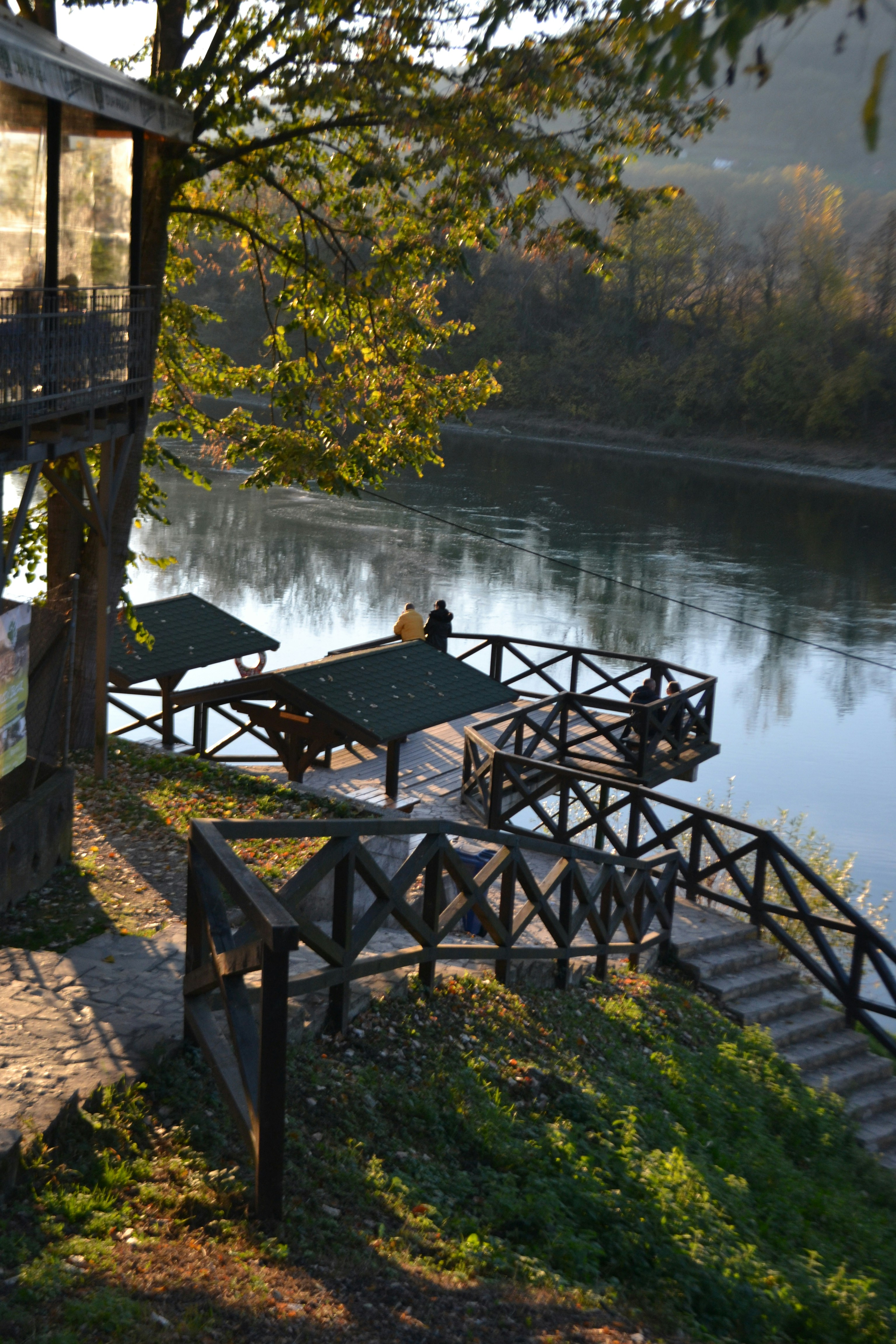 Sunlit Riverside Deck: Quiet Moment by the Water's Edge