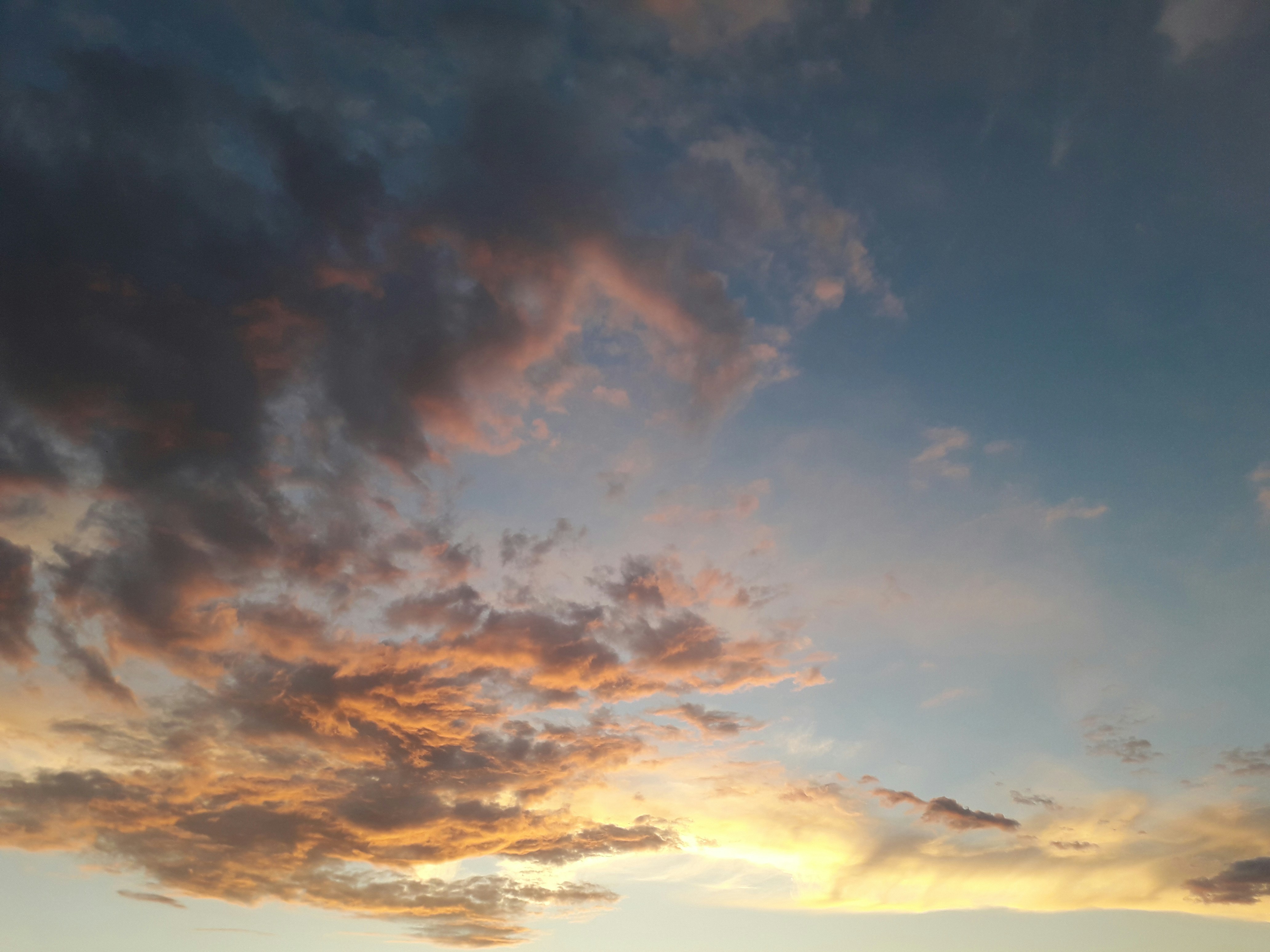 Vibrant clouds illuminated by the fading light of day, creating a serene atmosphere. The scene captures the transition from day to night.