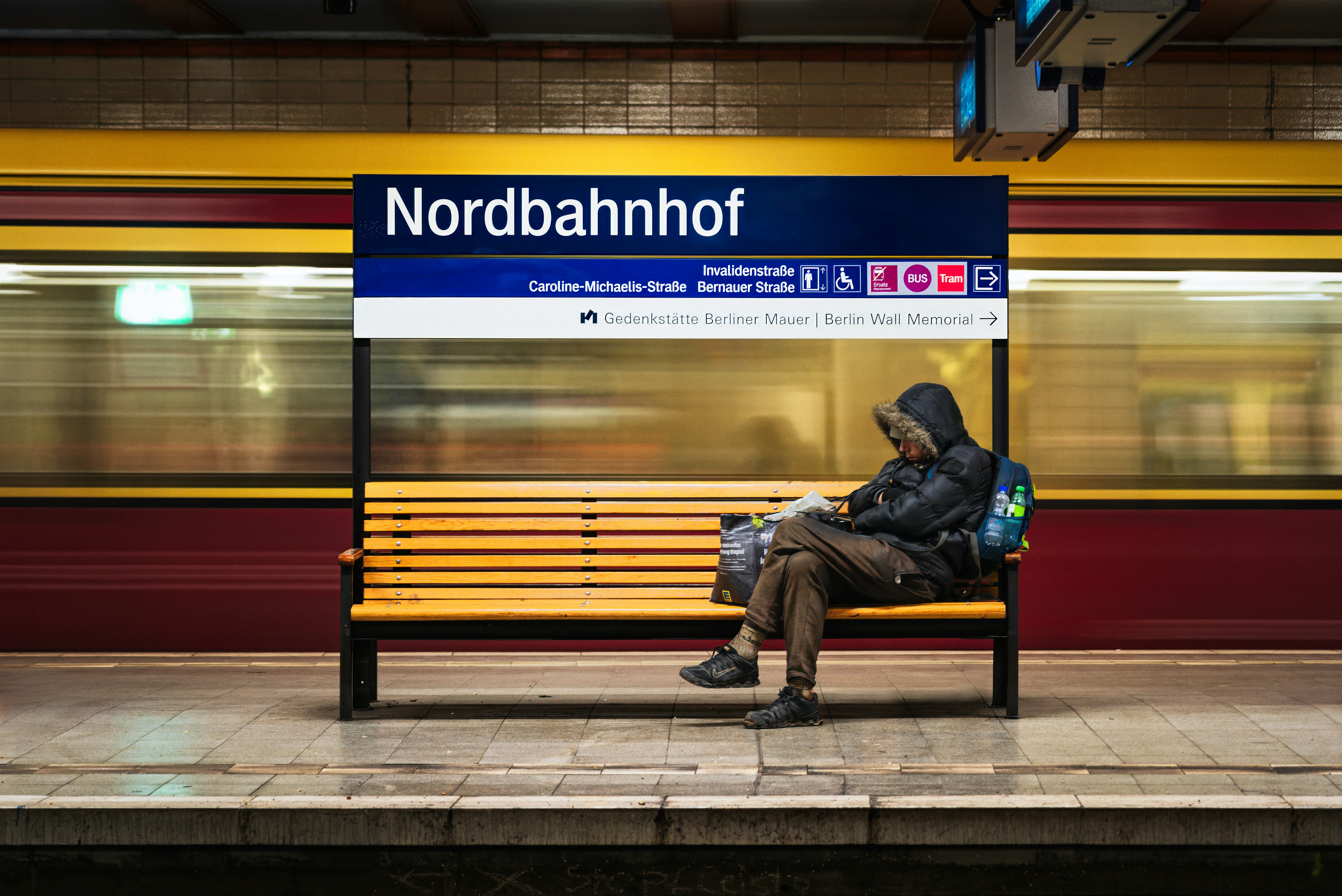Quiet Pause on the Platform: A Sleeper Portrait Beneath the Nordbahnhof Sign