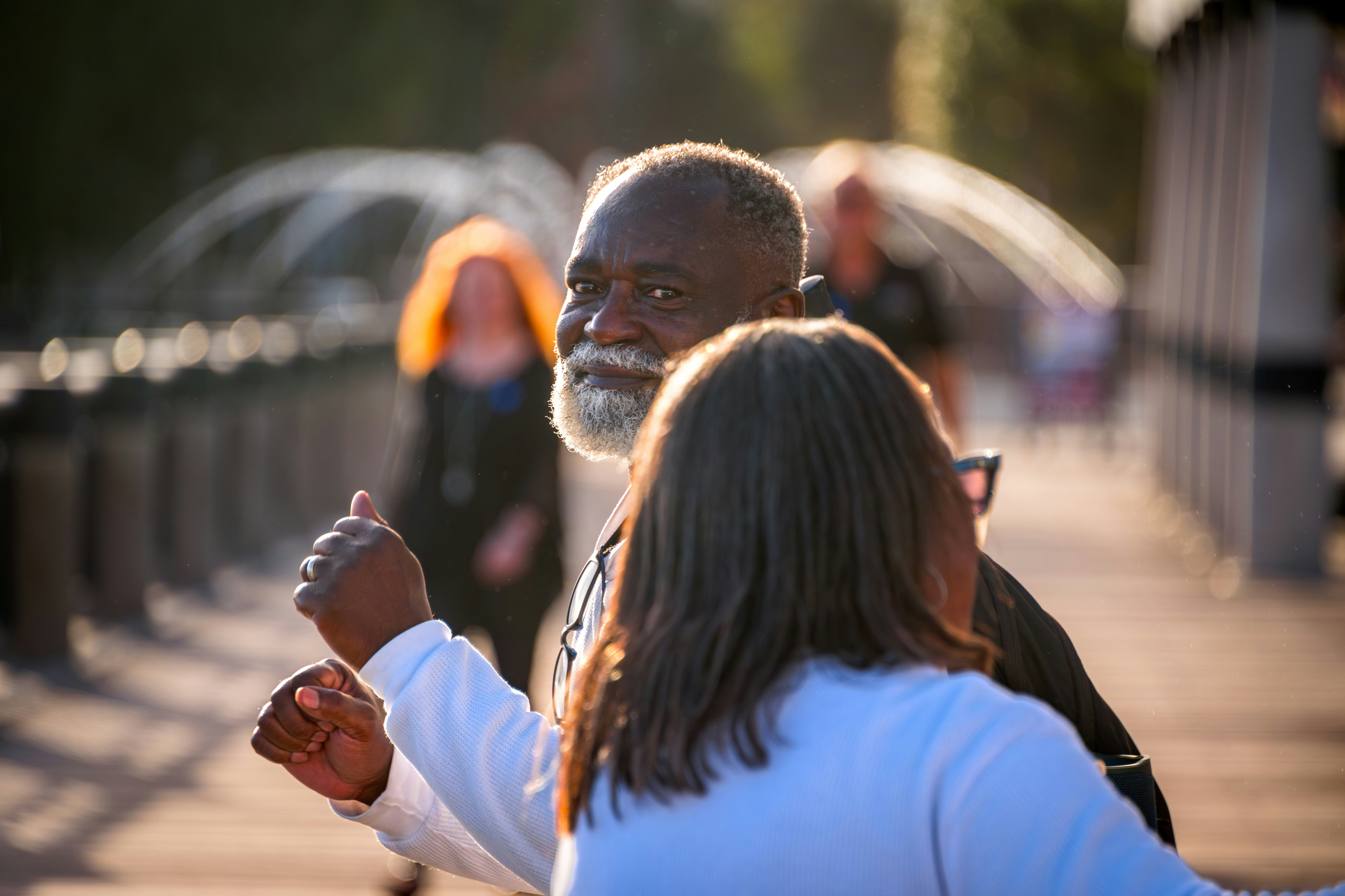 Golden Hour on the Pier: A Quiet Exchange Framed by Soft Fountains