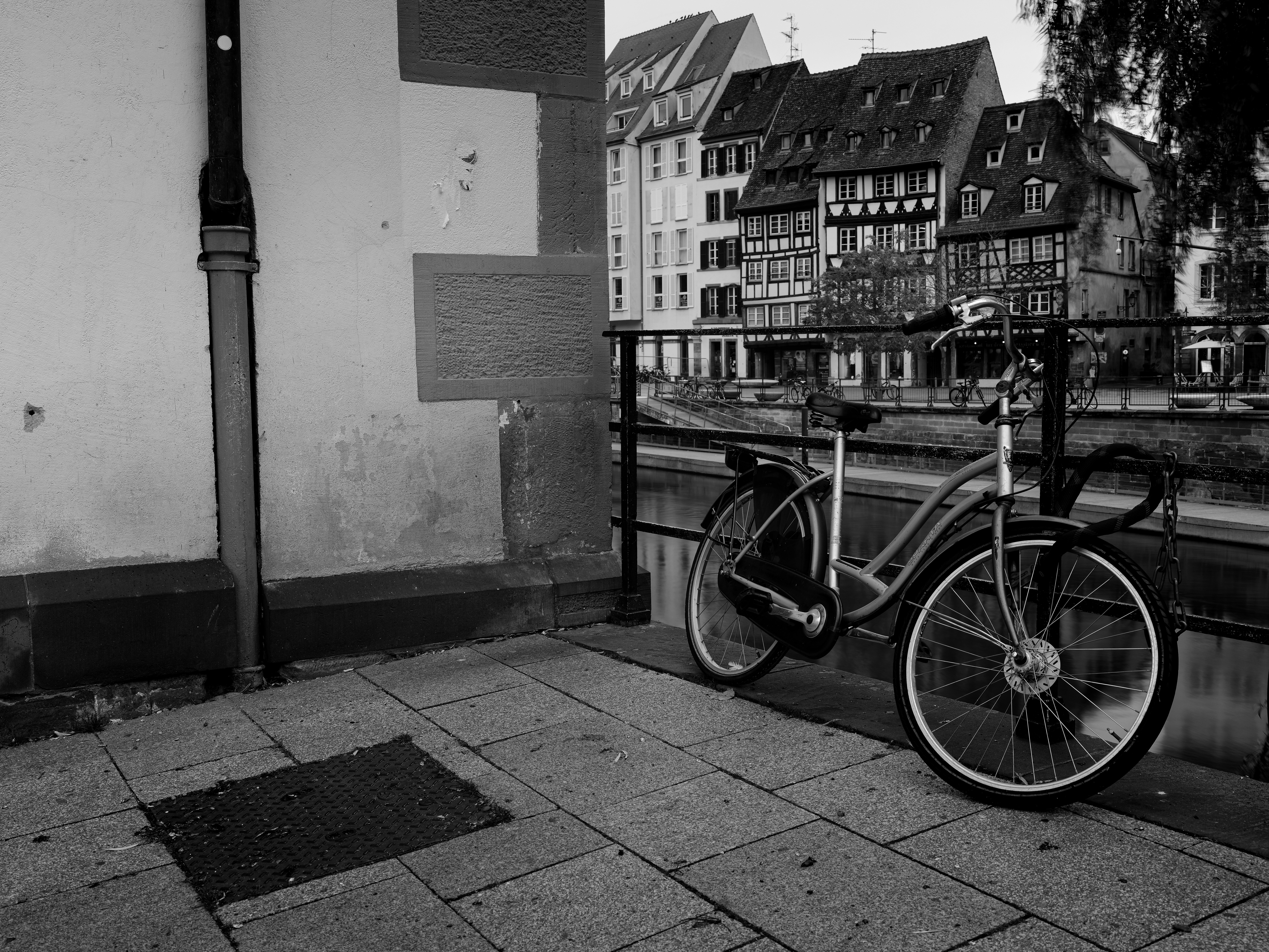 A quiet moment captured along the canal, featuring a parked bicycle and a serene streetscape. Shot with a long exposure to enhance the tranquil atmosphere and highlight the timeless beauty of urban life.