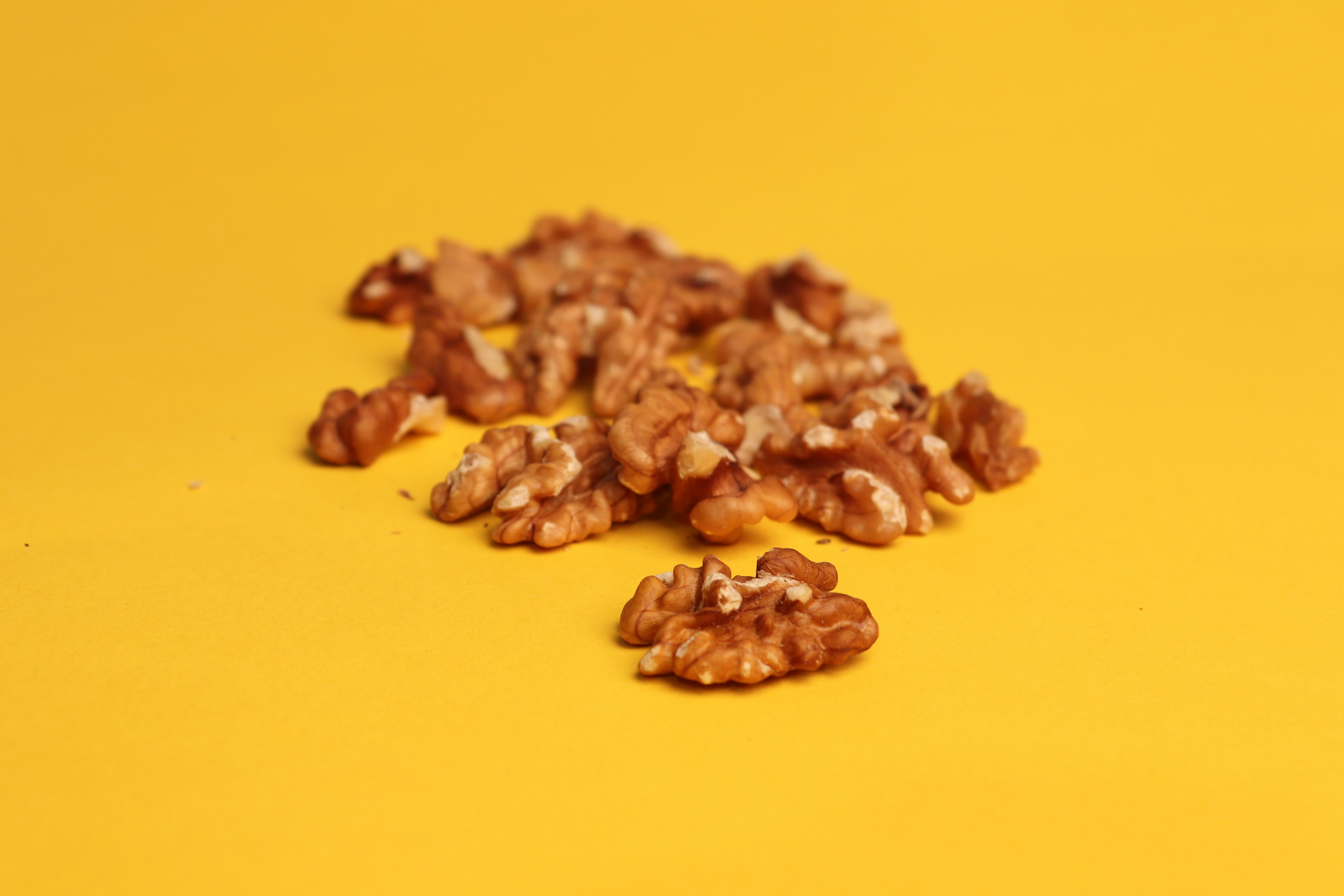 A pile of walnuts on a yellow background photo – Free Food Image on ...