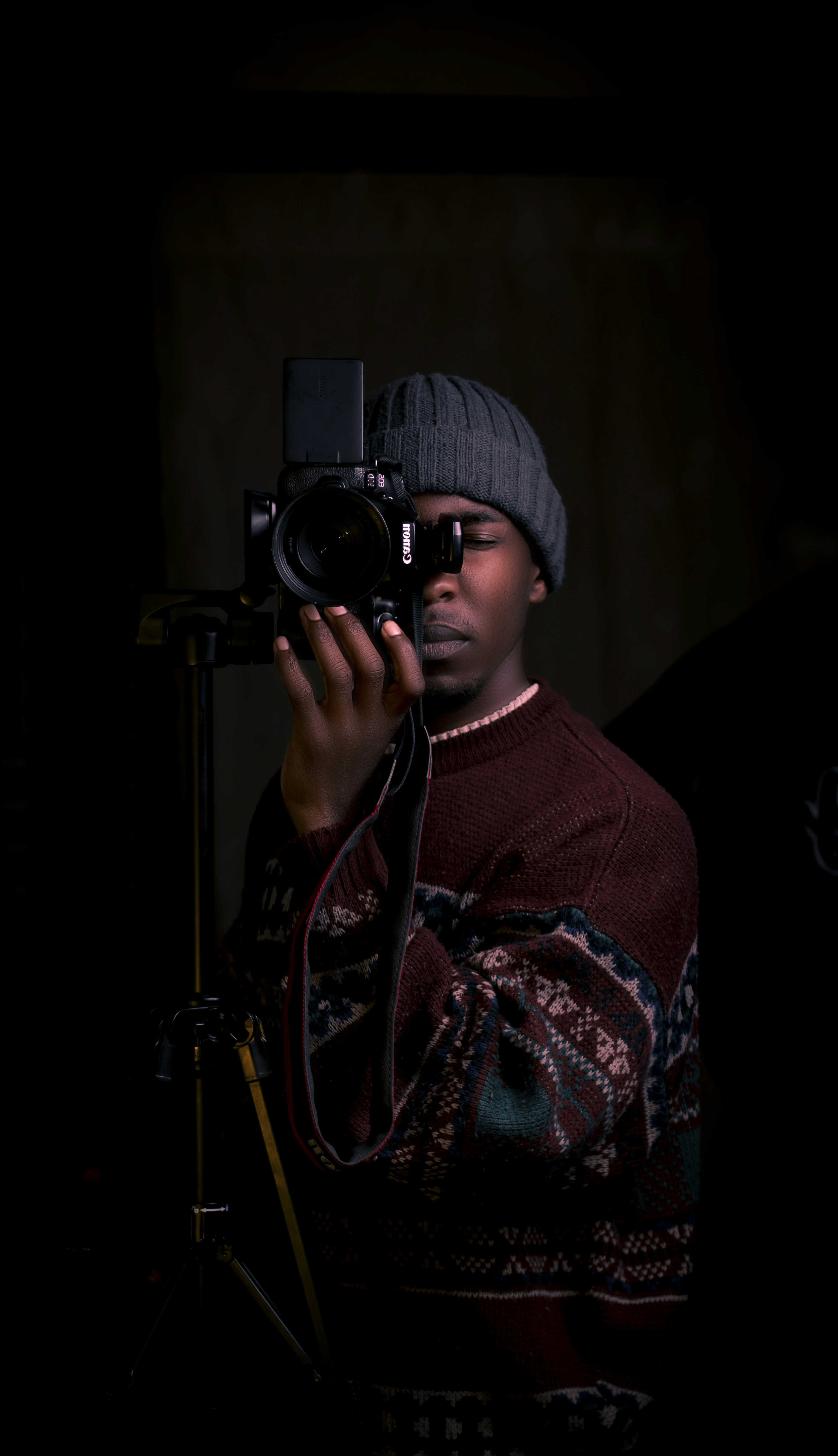 Studio Noir: Photographer Framed by Lens and Tripod