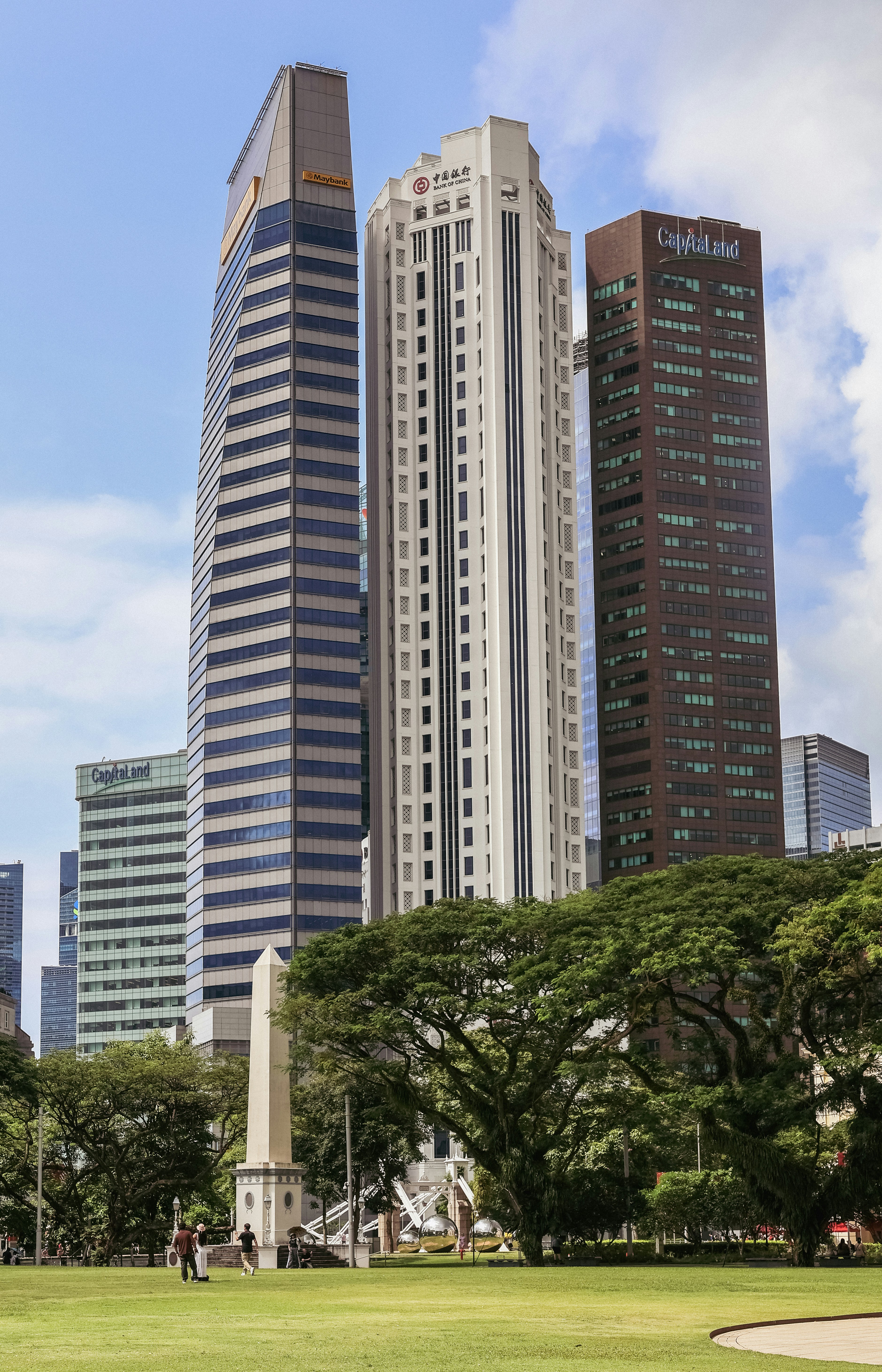 Tall skyscrapers in Singapore's financial district | A park in a city with tall buildings in the background