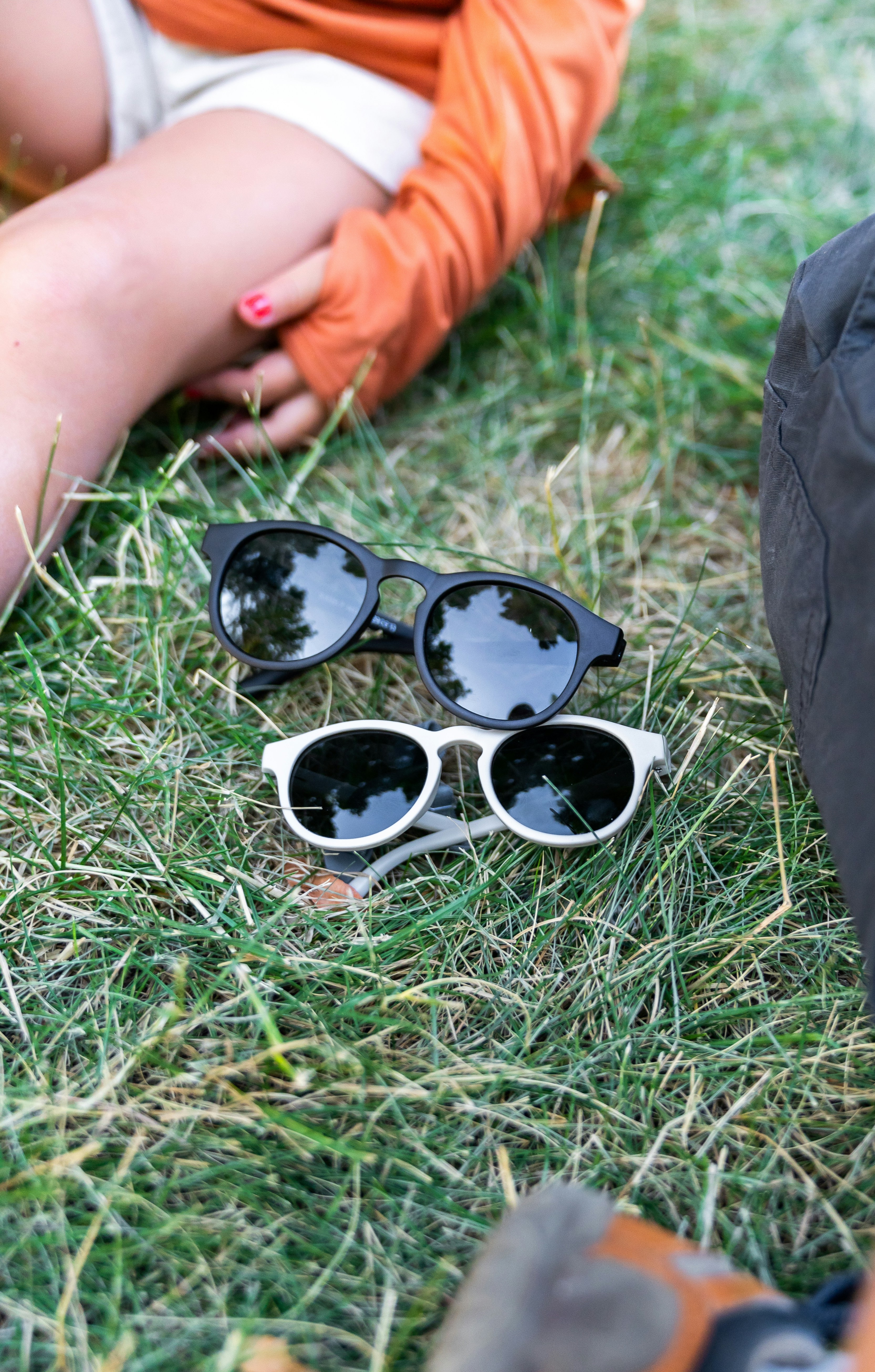 Sunlit Glasses Resting in Grass: A Quiet Picnic Moment