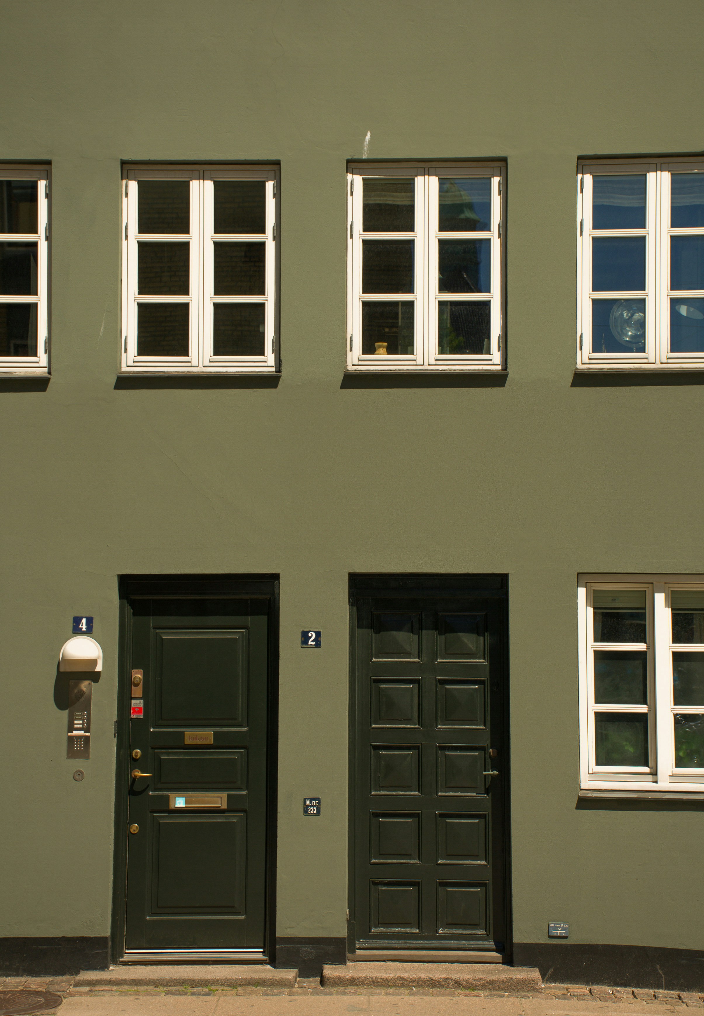 A green building with three doors and windows photo – Free Copenhagen ...