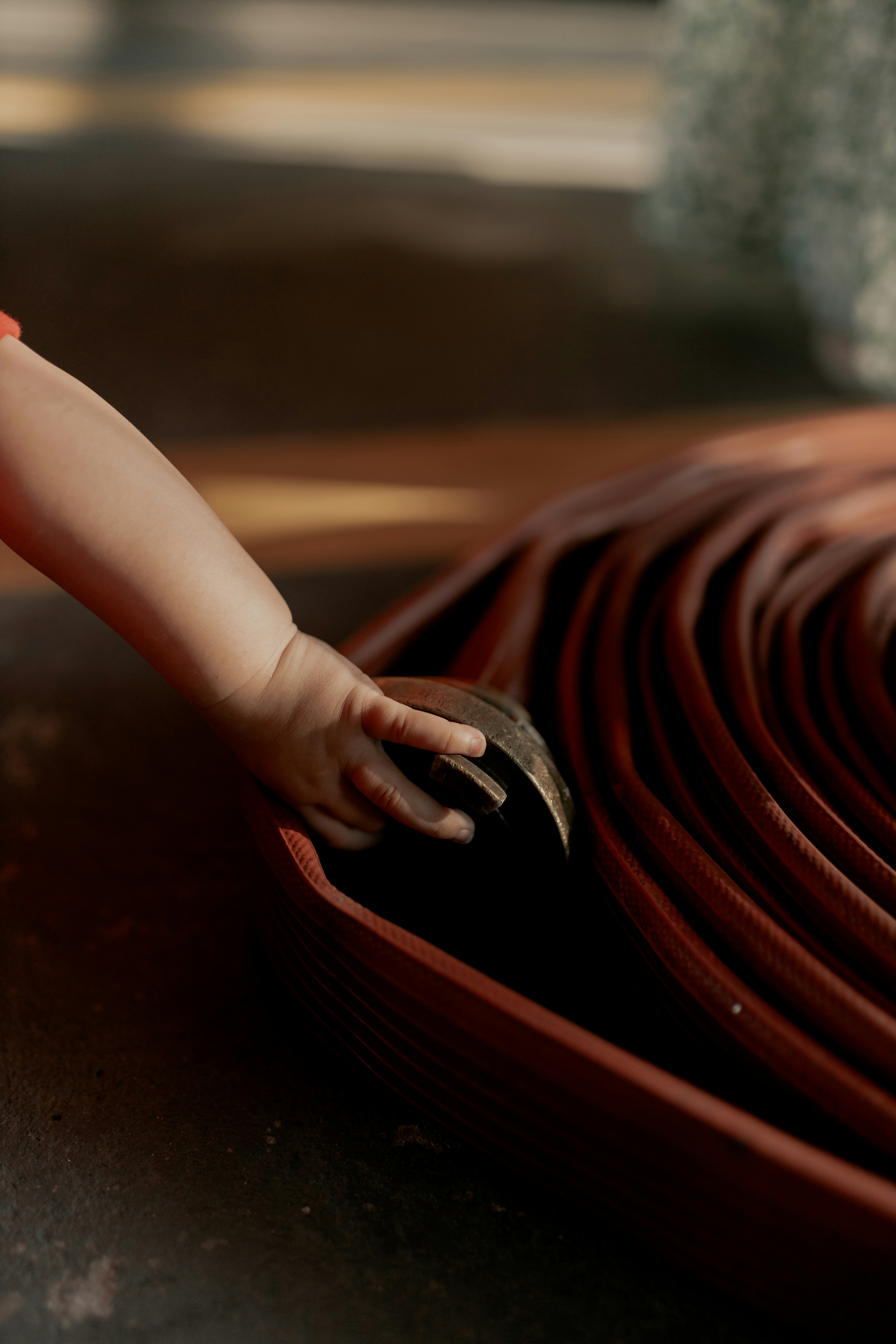 Tiny Grasp on a Red Coil: A Quiet Study in Texture and Light