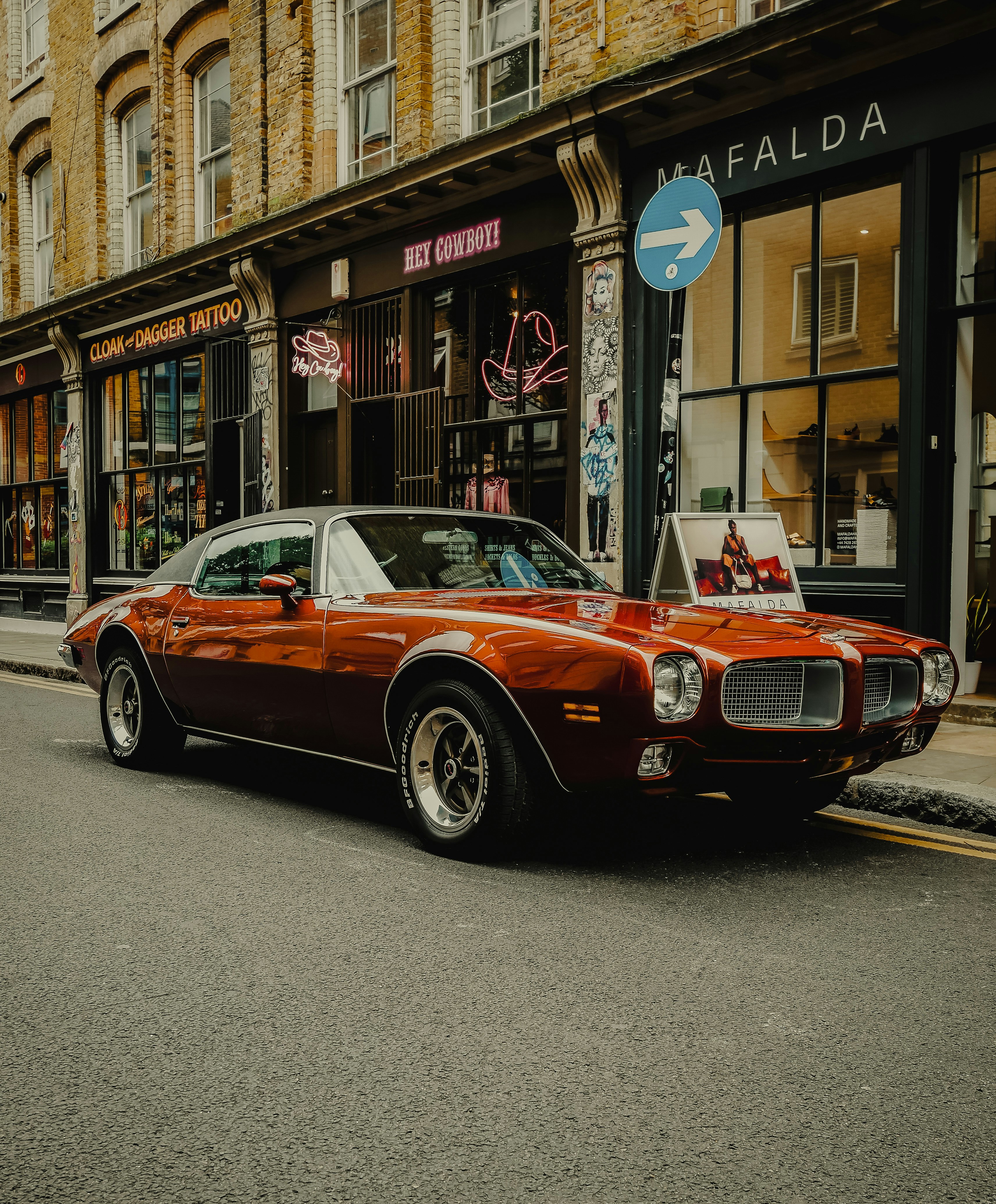 Crimson Muscle under Urban Sunlight: A 1969 Firebird on a Brick-Front Street