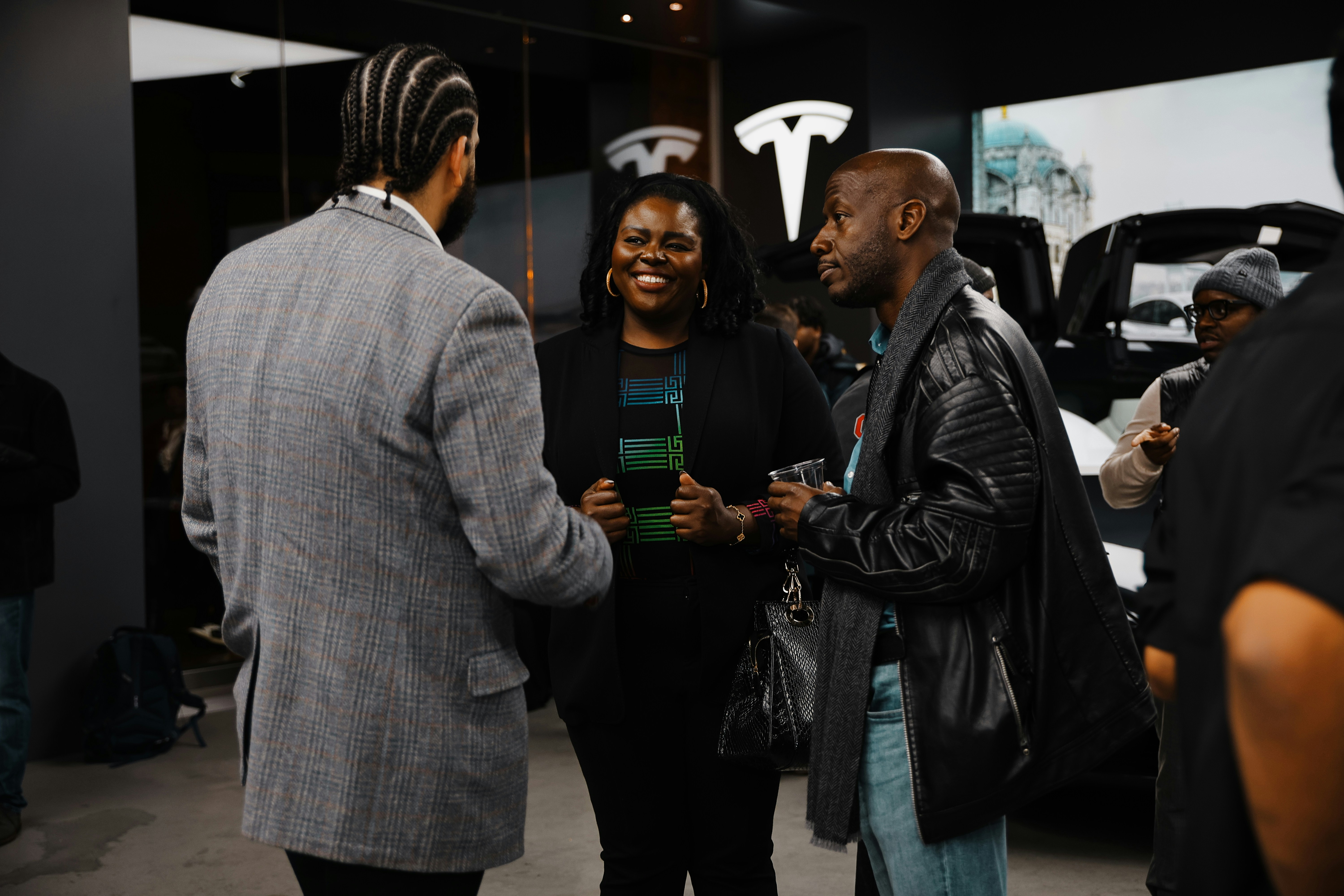 A group of people standing around talking to each other photo – Free ...