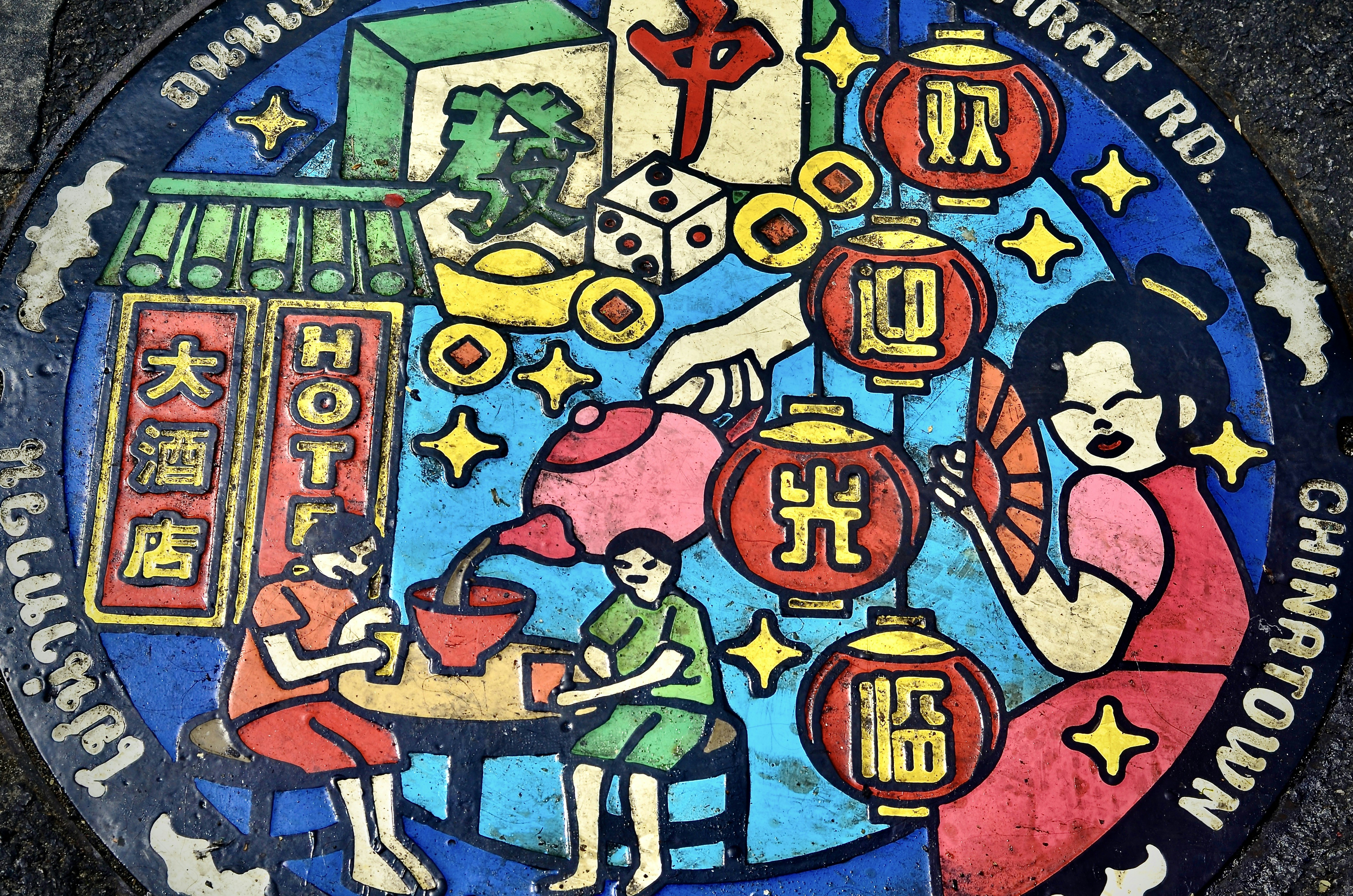 A manhole cover with a painting of people and symbols on it photo ...