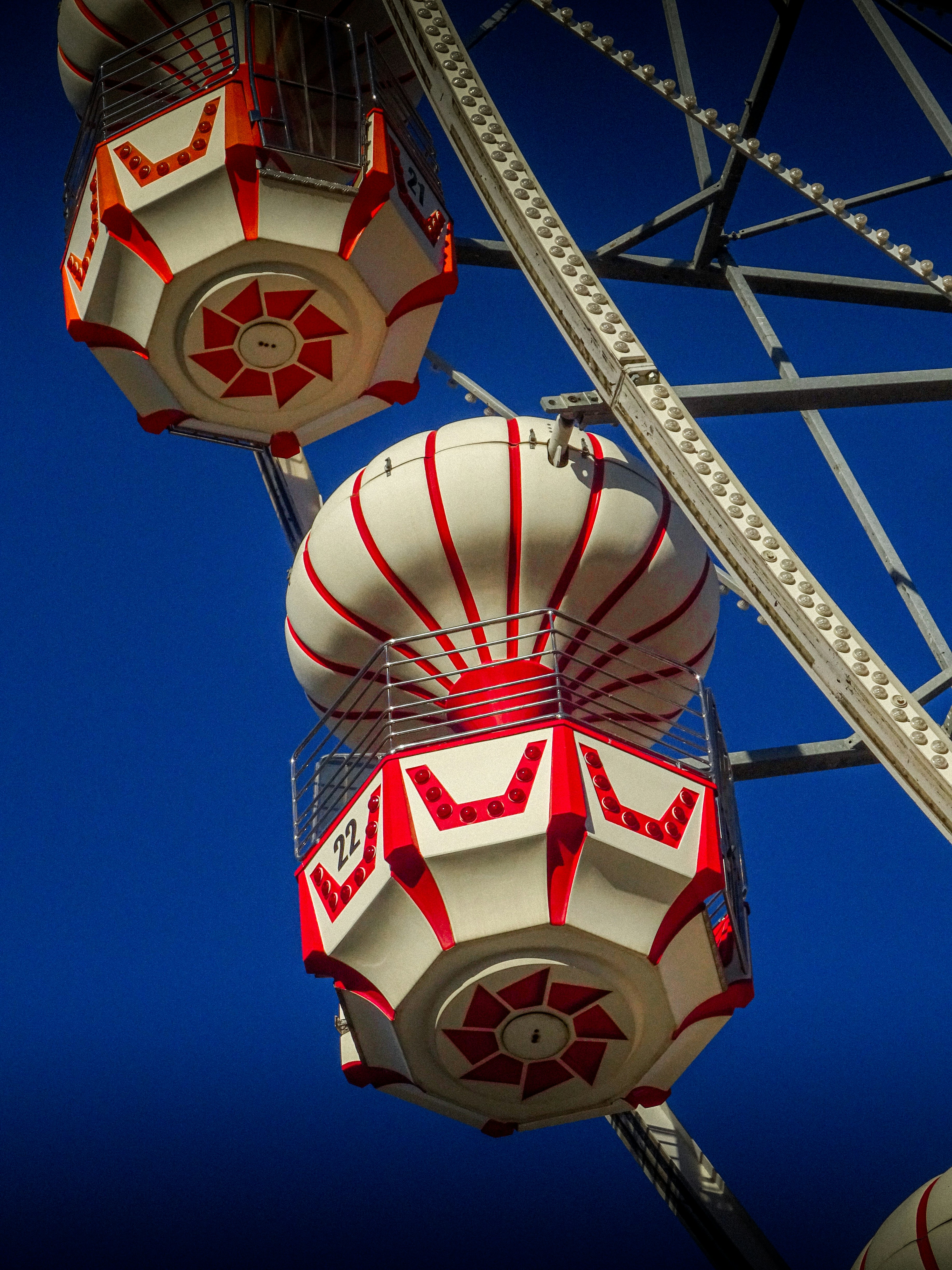 Ferris Wheel Pods Climb the Sky: Red and White Gondolas Against a Velvet Evening