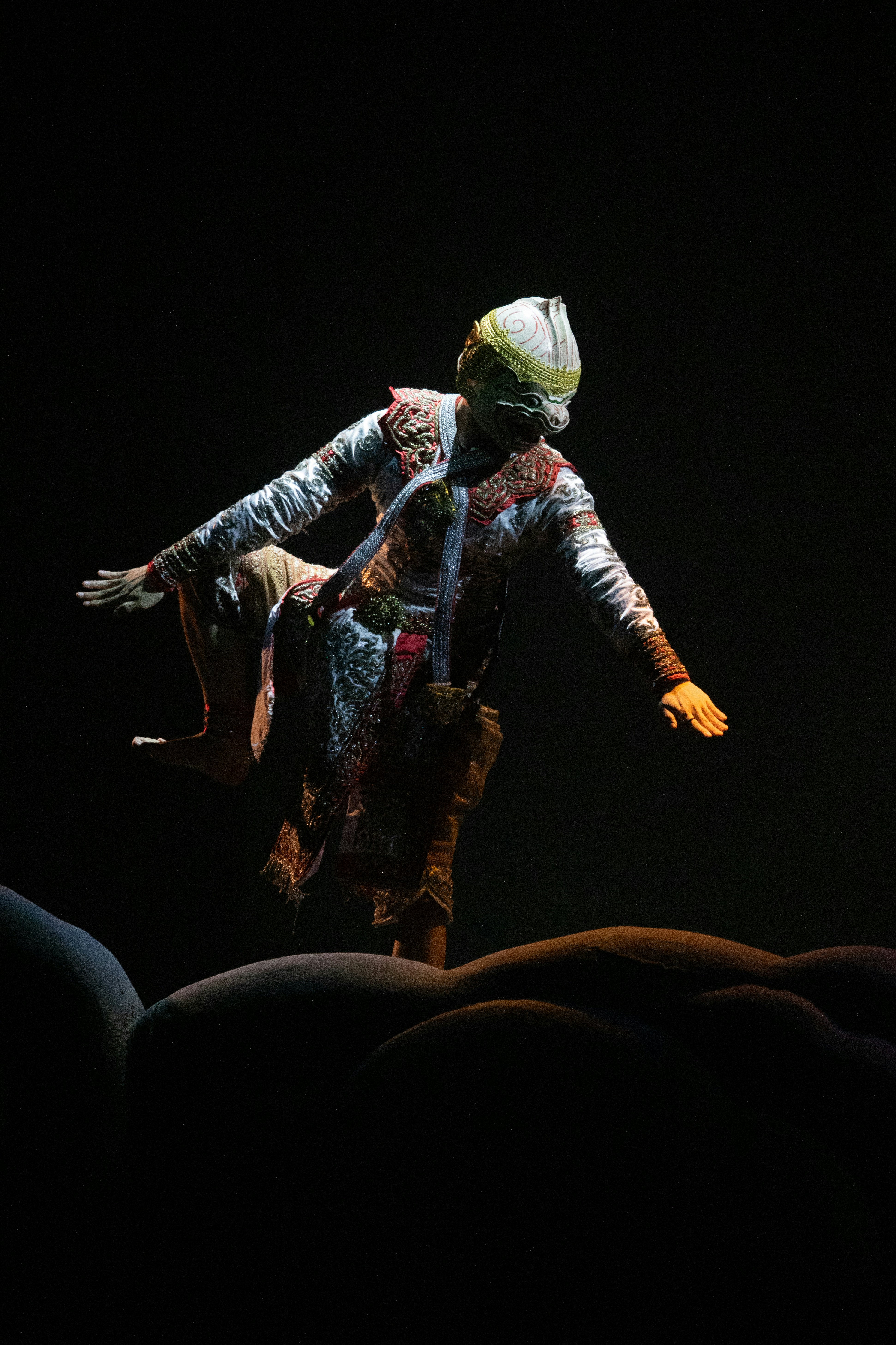 Grace in the Void: A Masked Performer Hovering Over Velvet Shadows