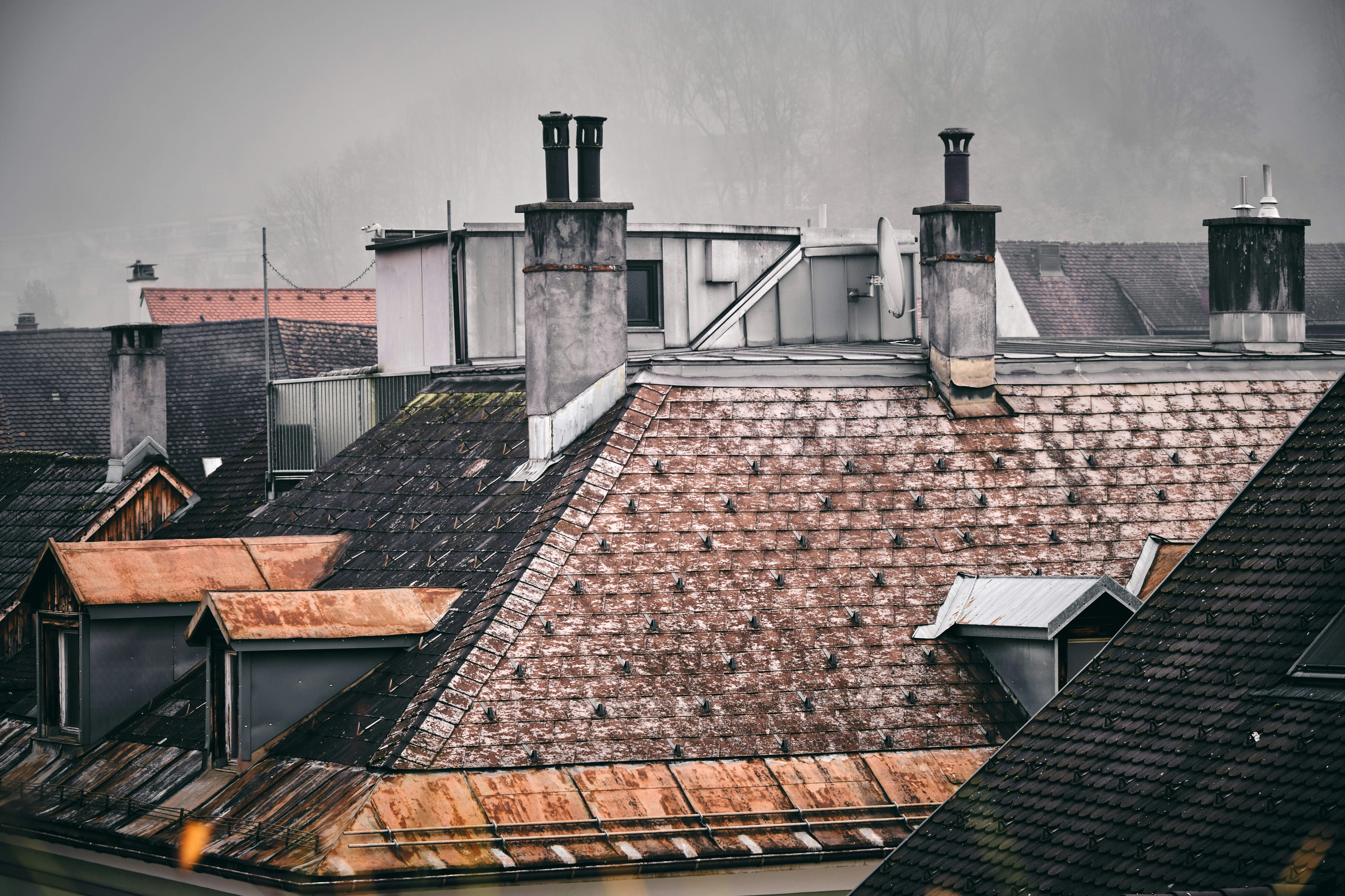 A row of rooftops with chimneys and tiled roofs photo – Free Feldkirch ...