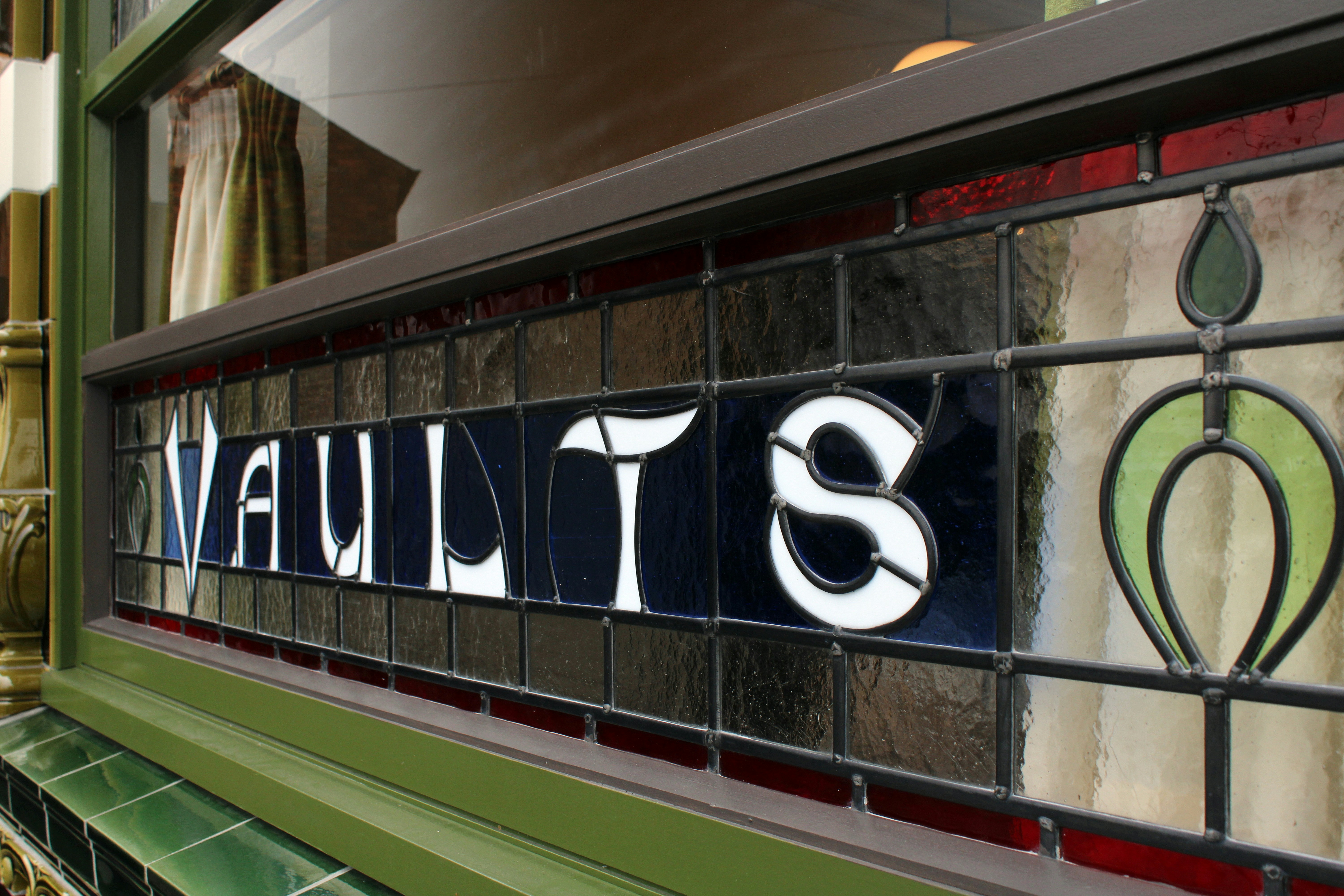 Stained Glass Signage Through a Wrought-Iron Window