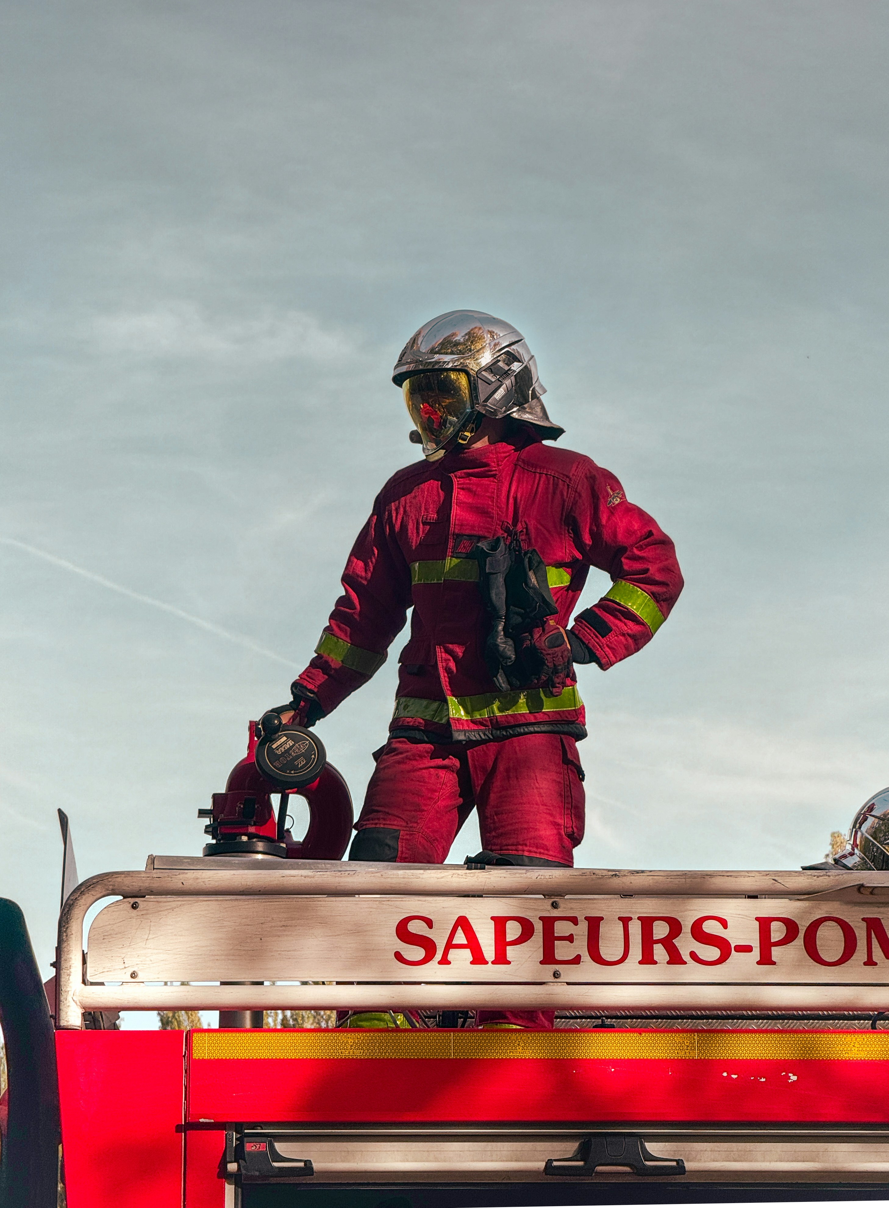 Crimson Sentinel: Firefighter Stands atop a Red Rig
