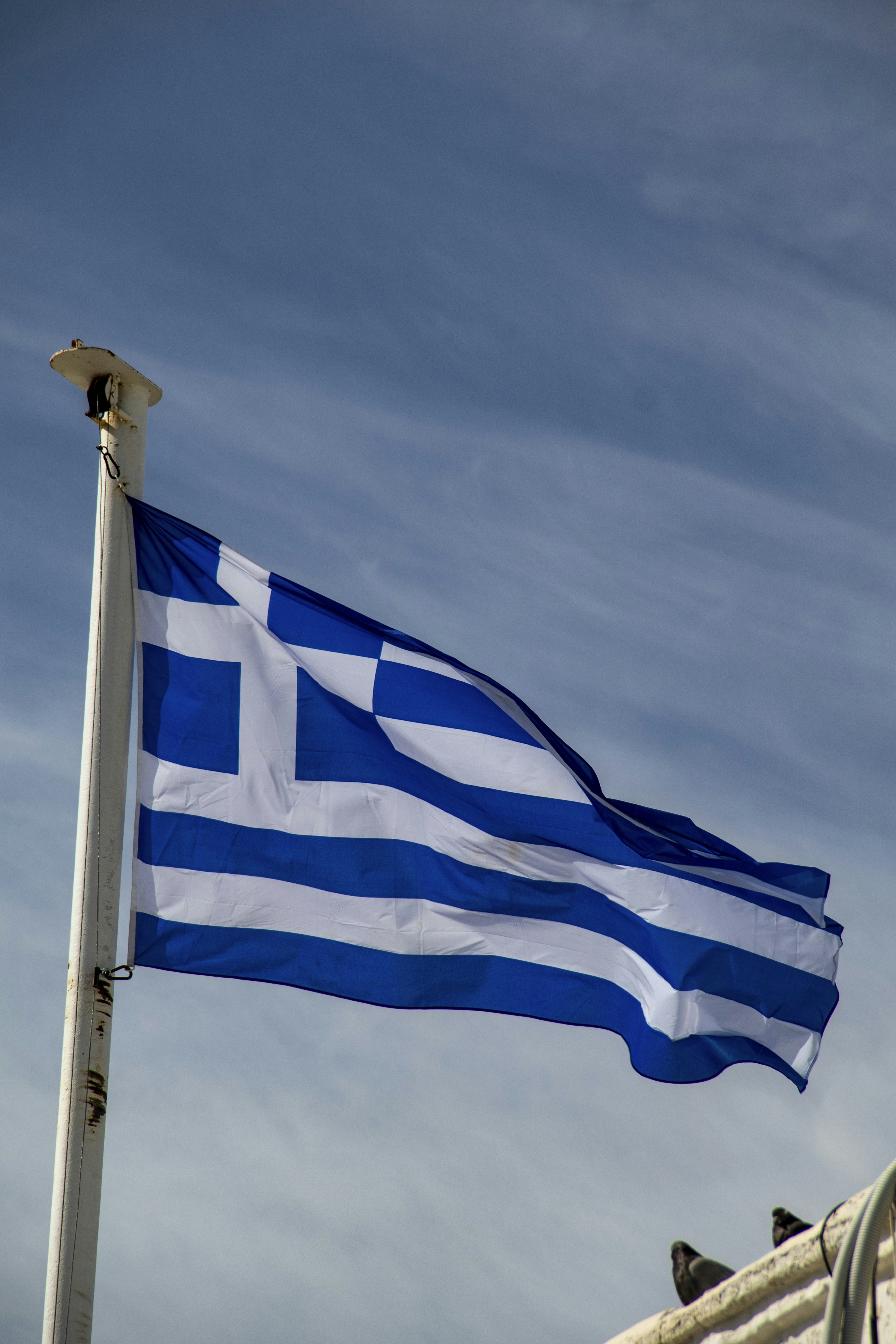 Blue-and-White Greek Flag Unfurling Under a Cerulean Sky